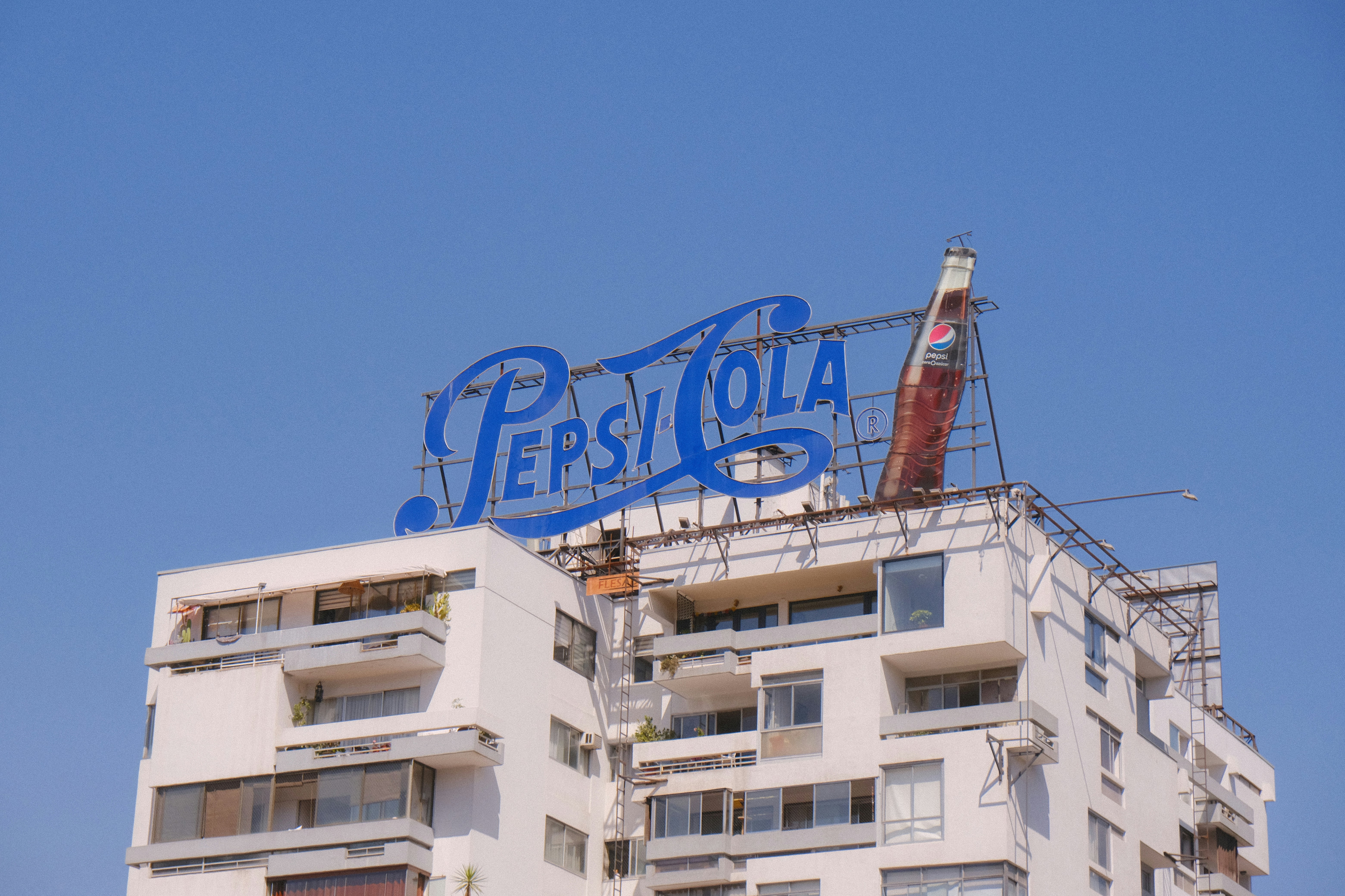 A pepsi cola sign on top of a building photo – Free Neon light Image on ...