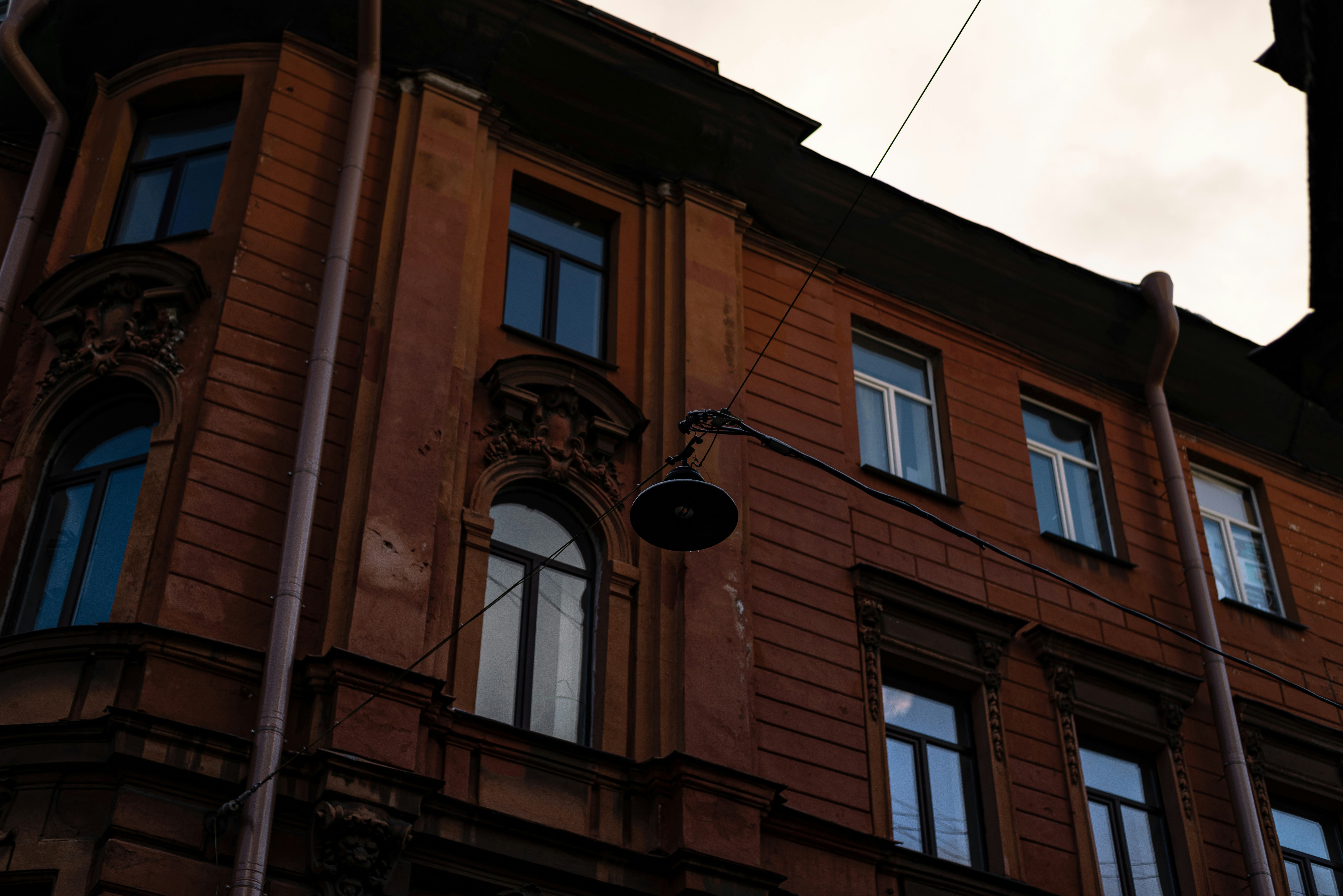 Ornate Brick Facade with a Hanging Lantern at Dusk