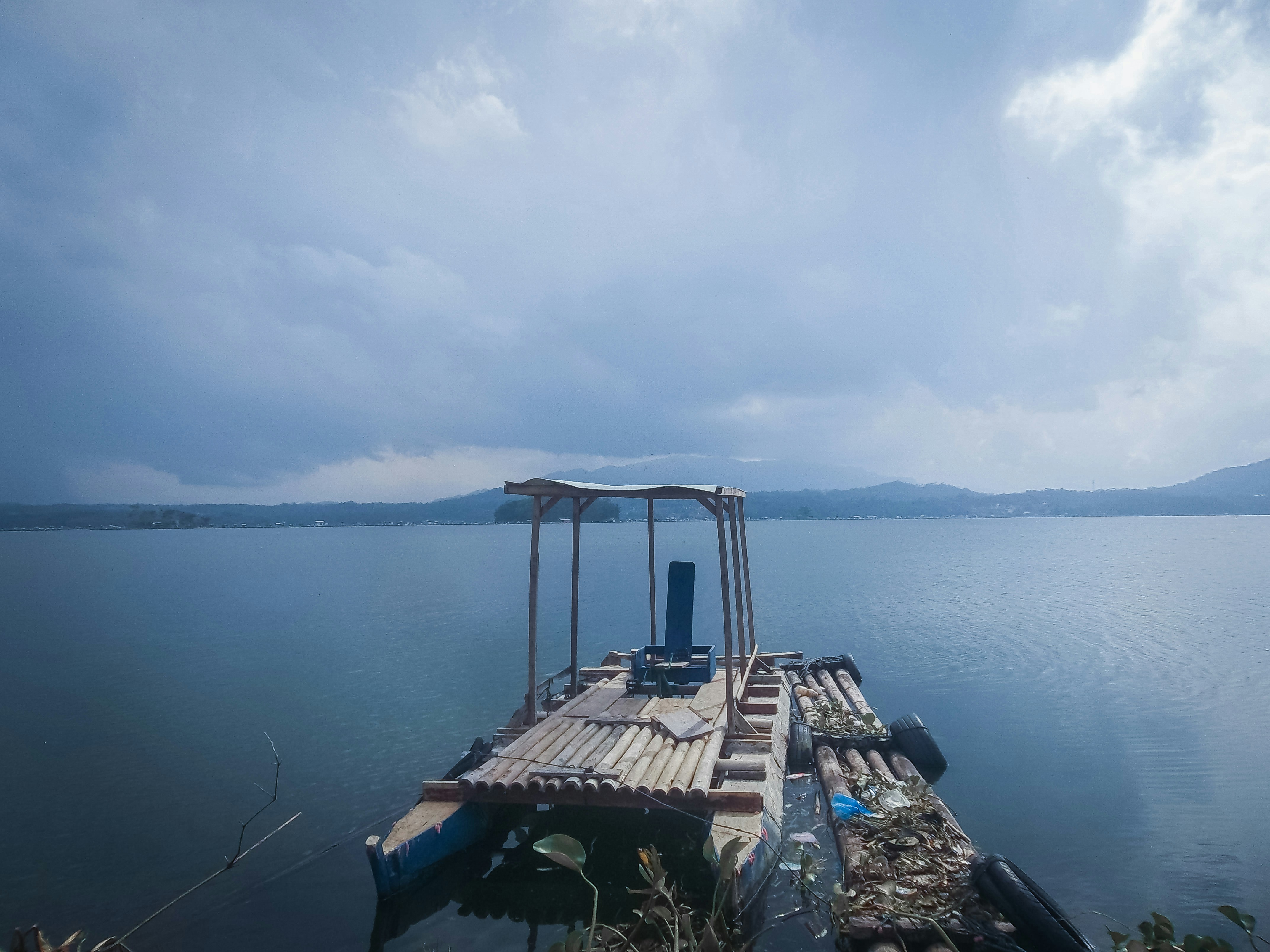 a dock on a lake with a chair on it