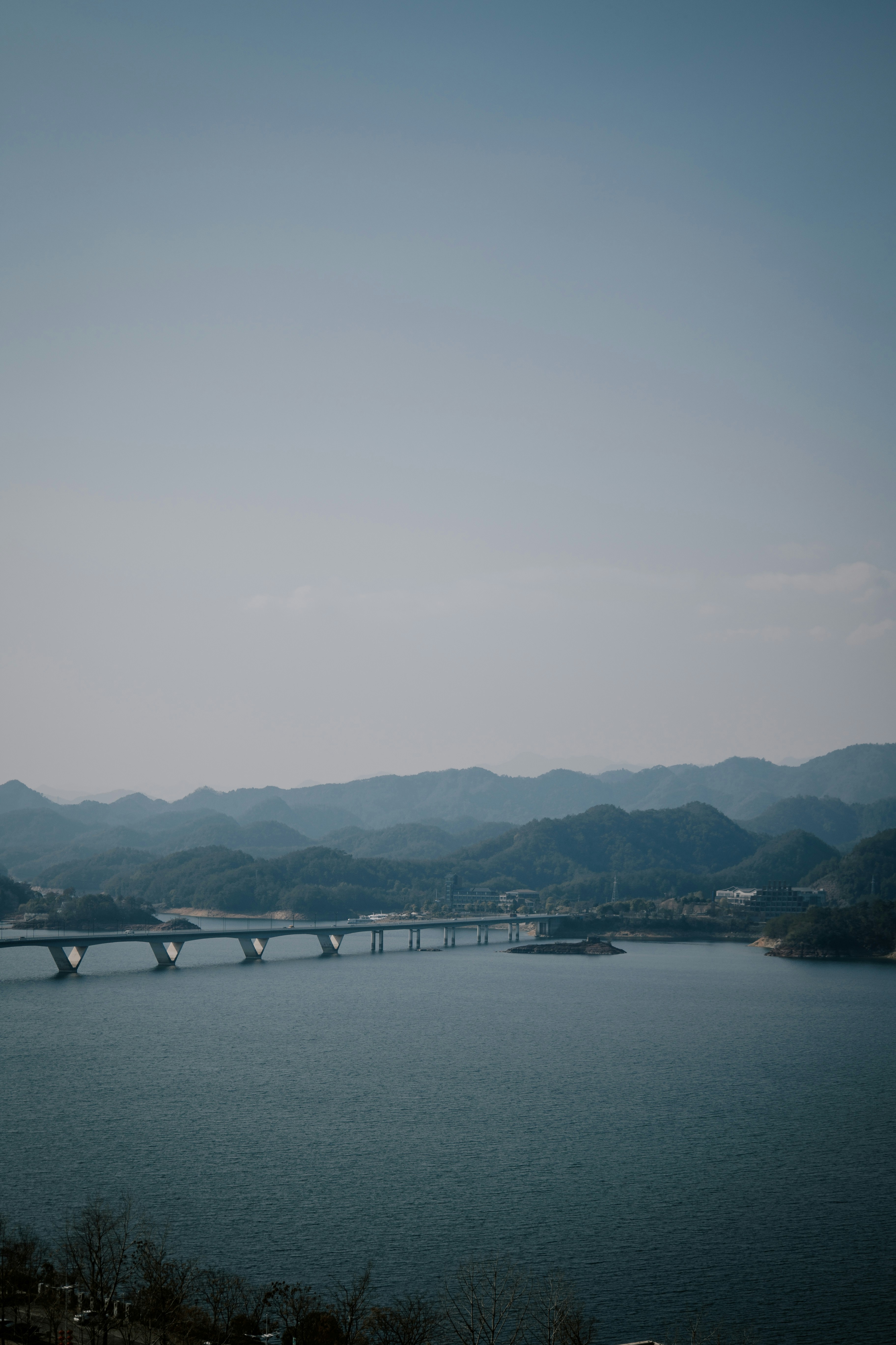A large body of water with a bridge in the background photo – Free Lake ...