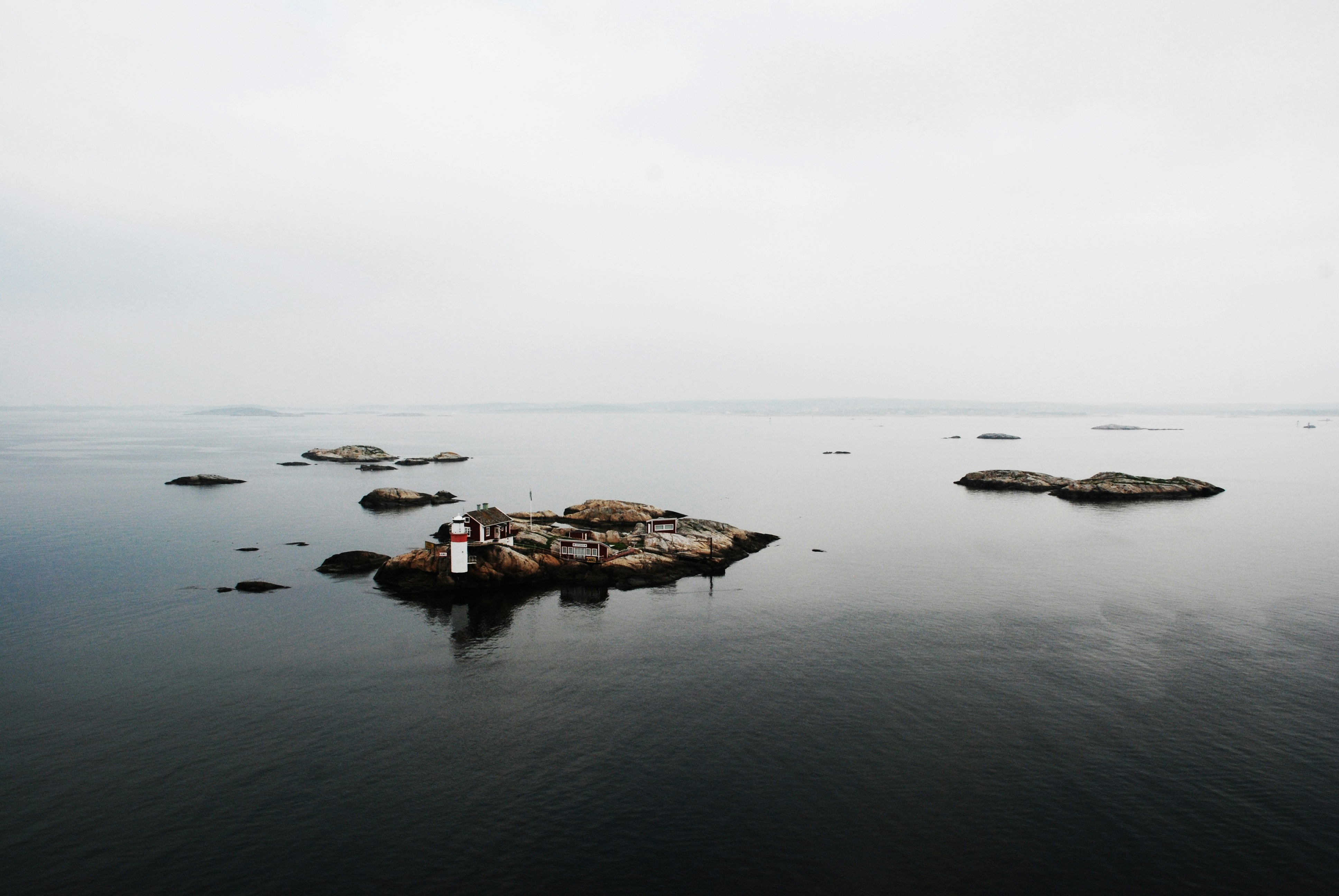 A small island in the middle of a body of water photo – Free Waterscape ...