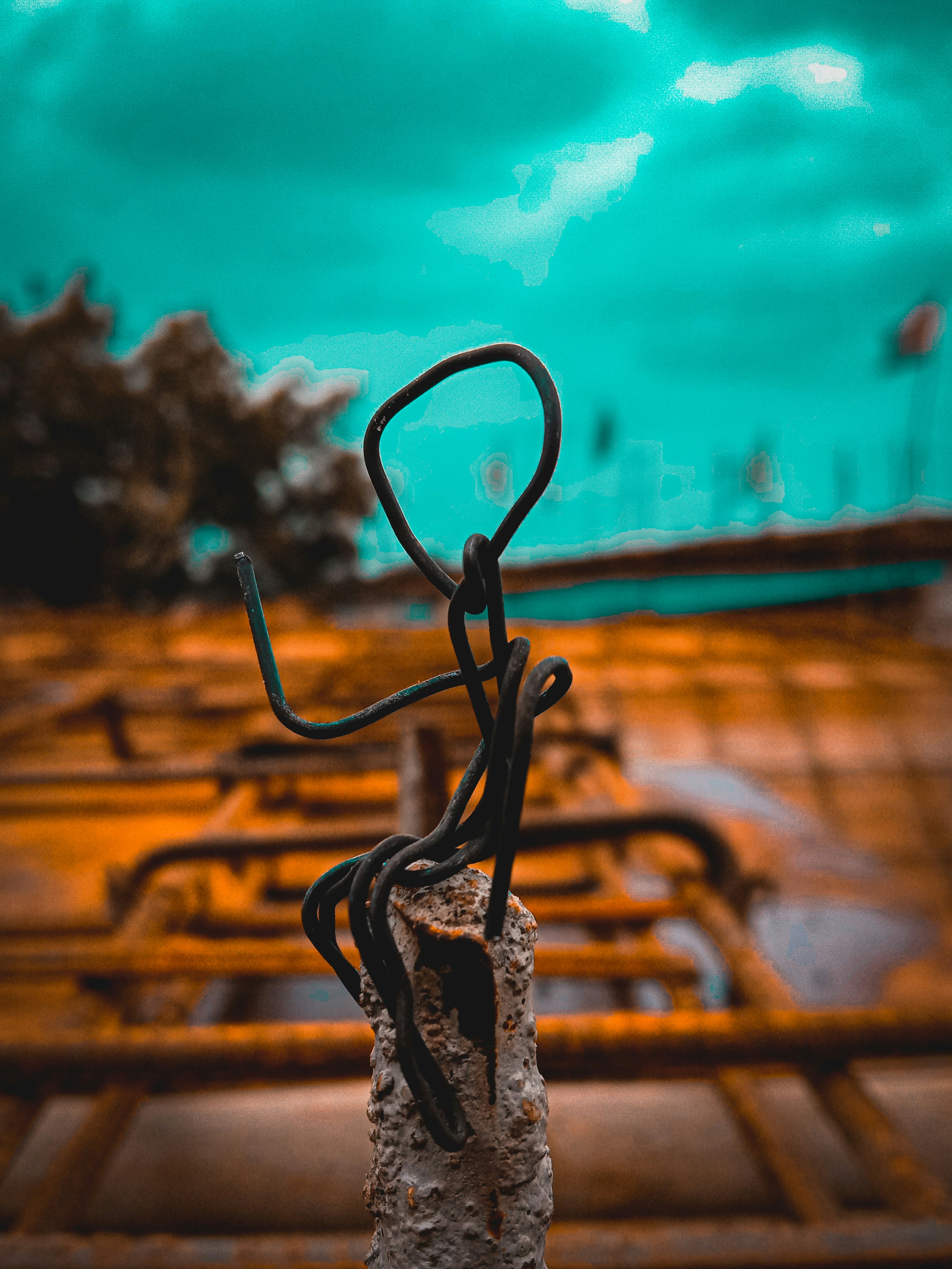 Teal Sky, Rusted Loop: Close-Up on Weathered Steel