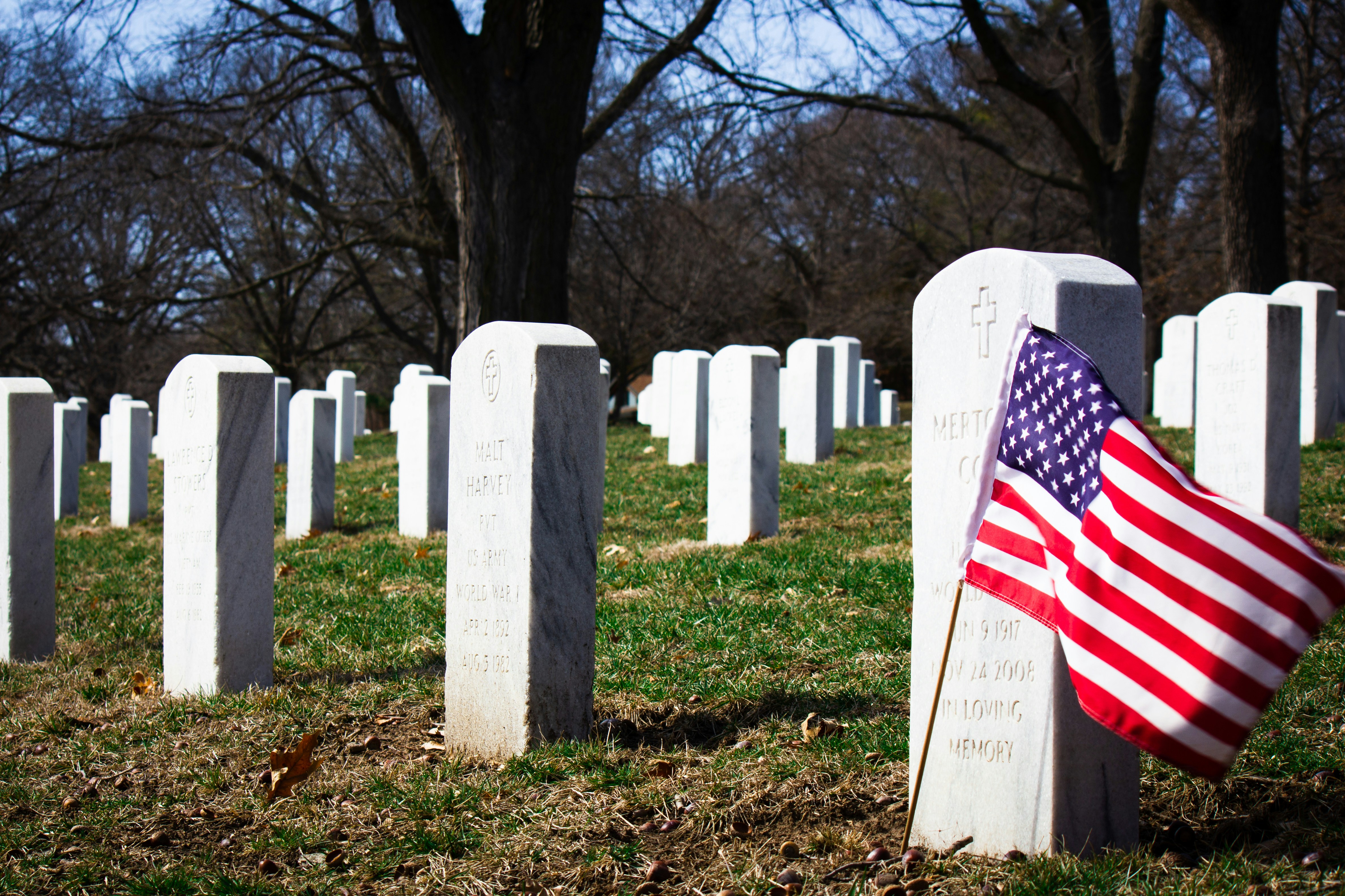 A gentle breeze waves an American flag over a fallen soldier's gravesite