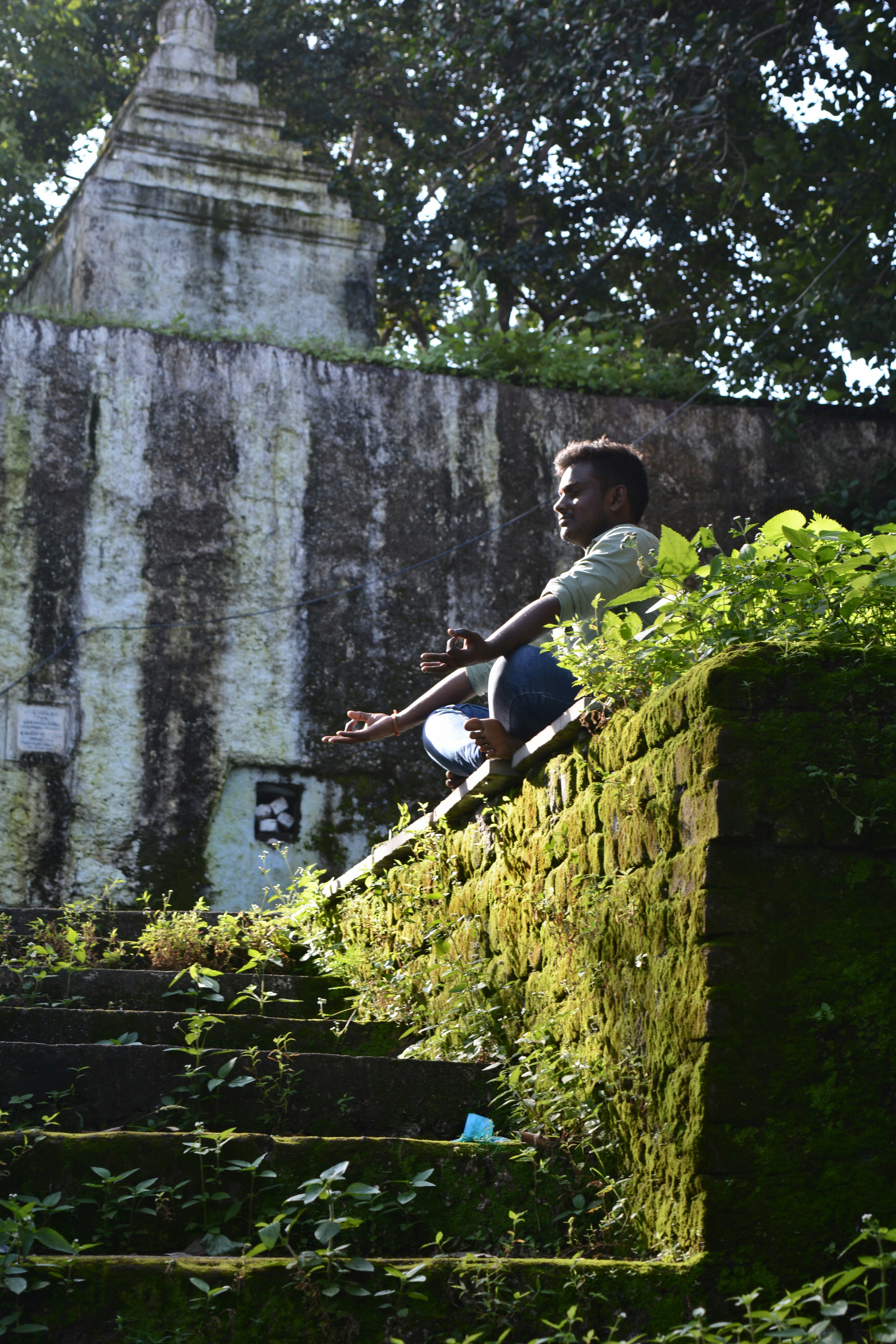 Mossy Terrace Pause: A Man on the Weathered Wall