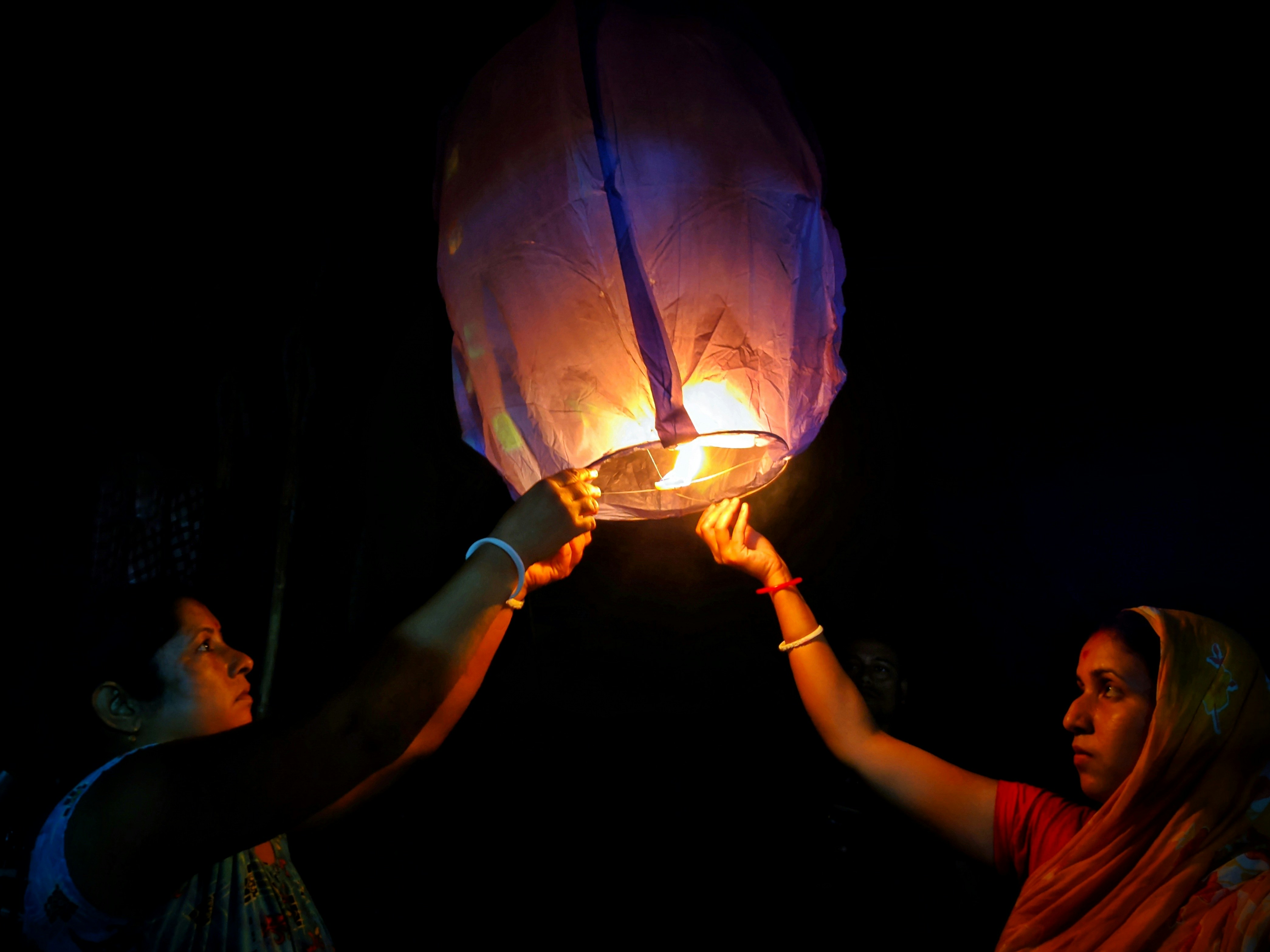 Foto Dos mujeres sosteniendo una linterna encendida en la oscuridad ...