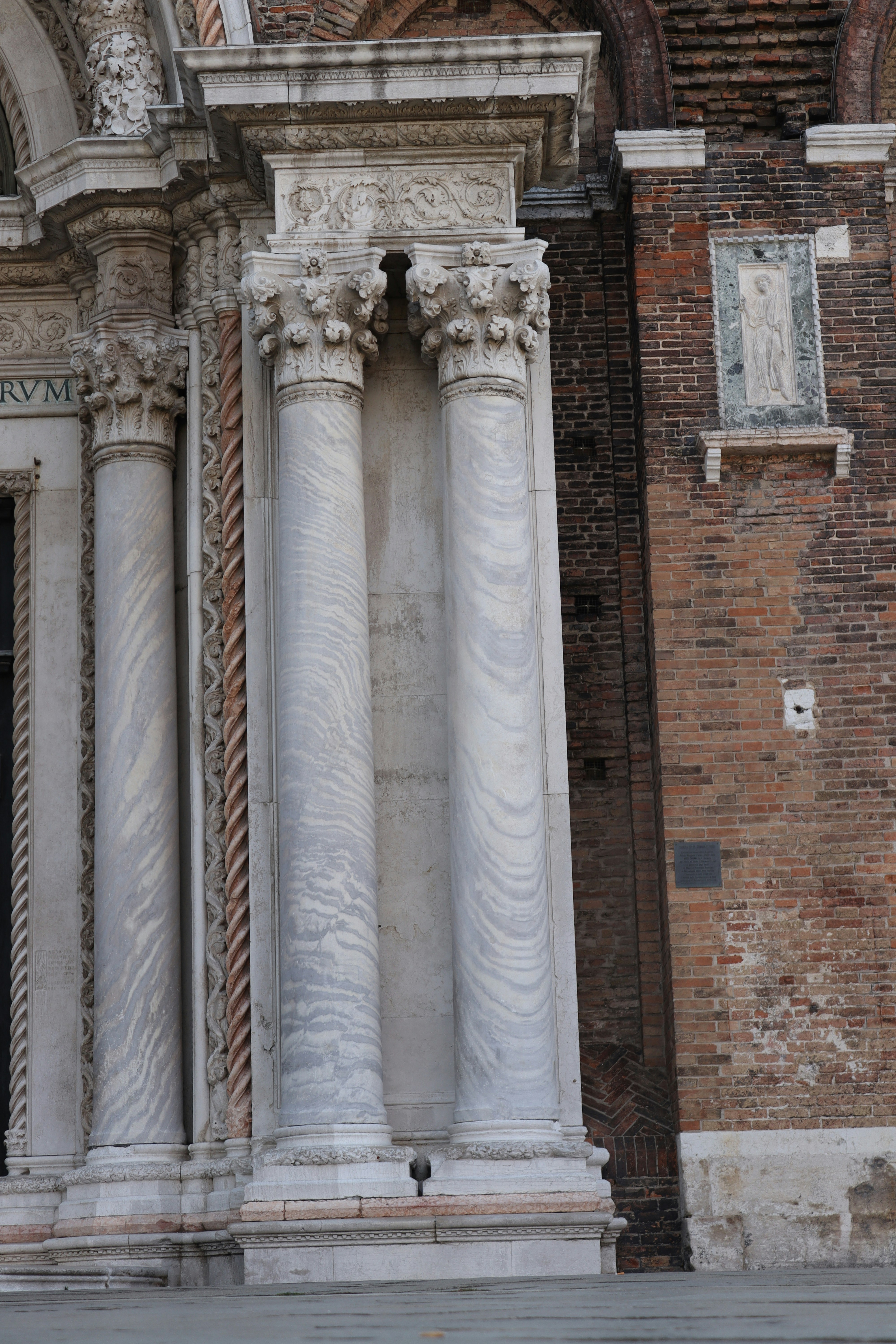 Marble Column Chorus Framing a Rustic Brick Facade