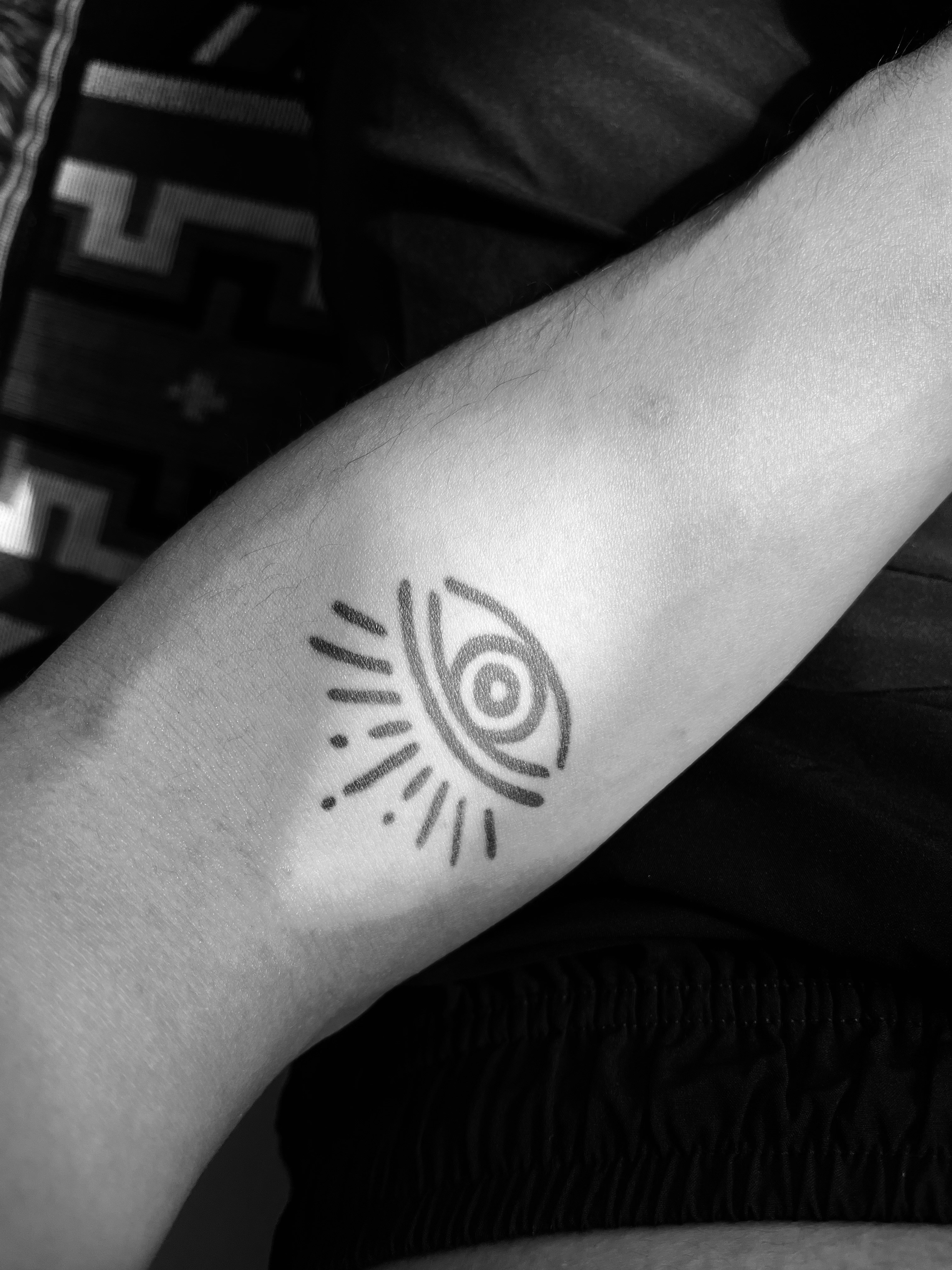 a black and white photo of a person's arm with a tattoo on it