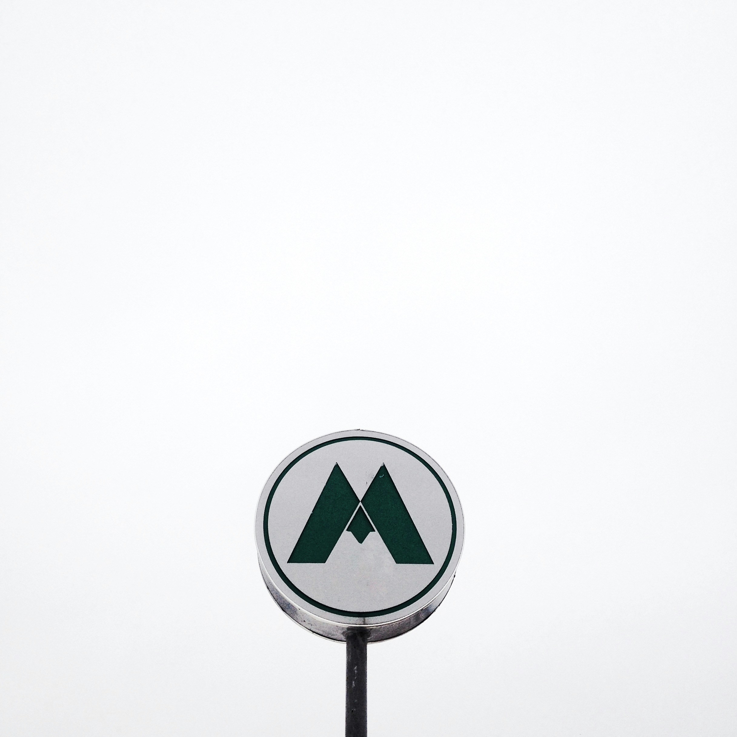 Minimalist Metrocrest Emblem: A Circular Logo Rising from White Sky