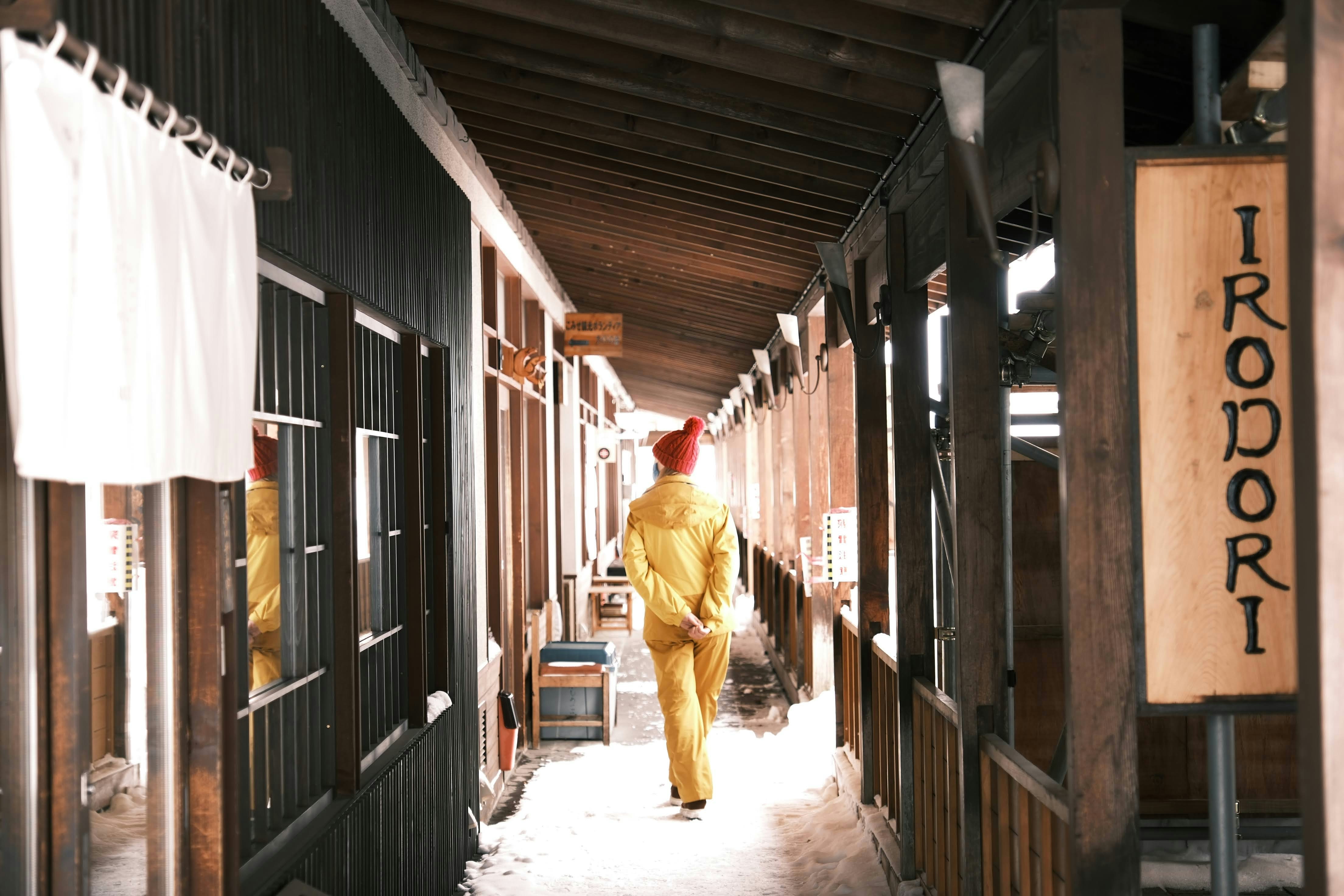 Yellow-Clad Wanderer in a Snow-Dusted Arcade
