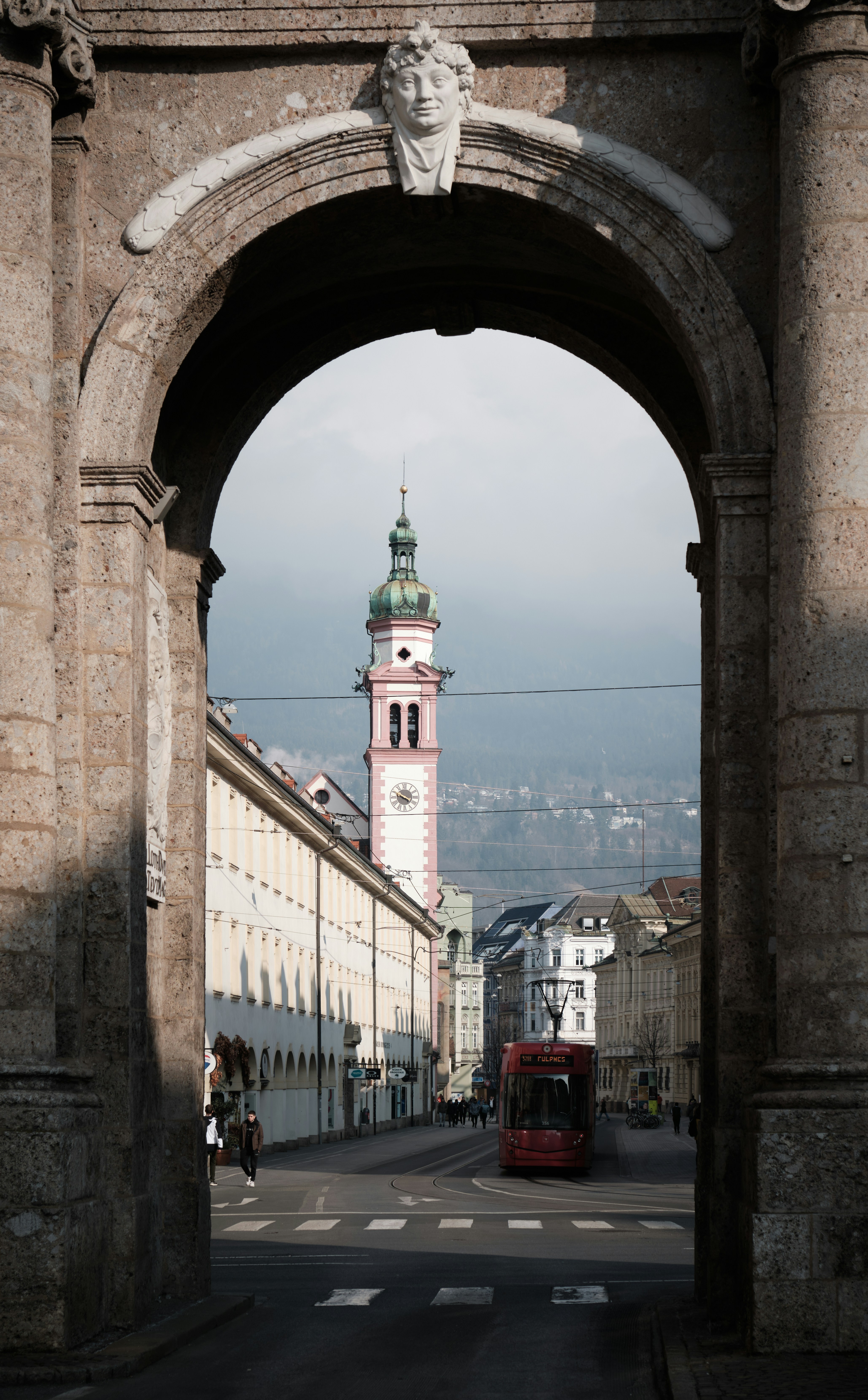 Through the Stone Arch: A City Gate Framing a Stately Clock Tower