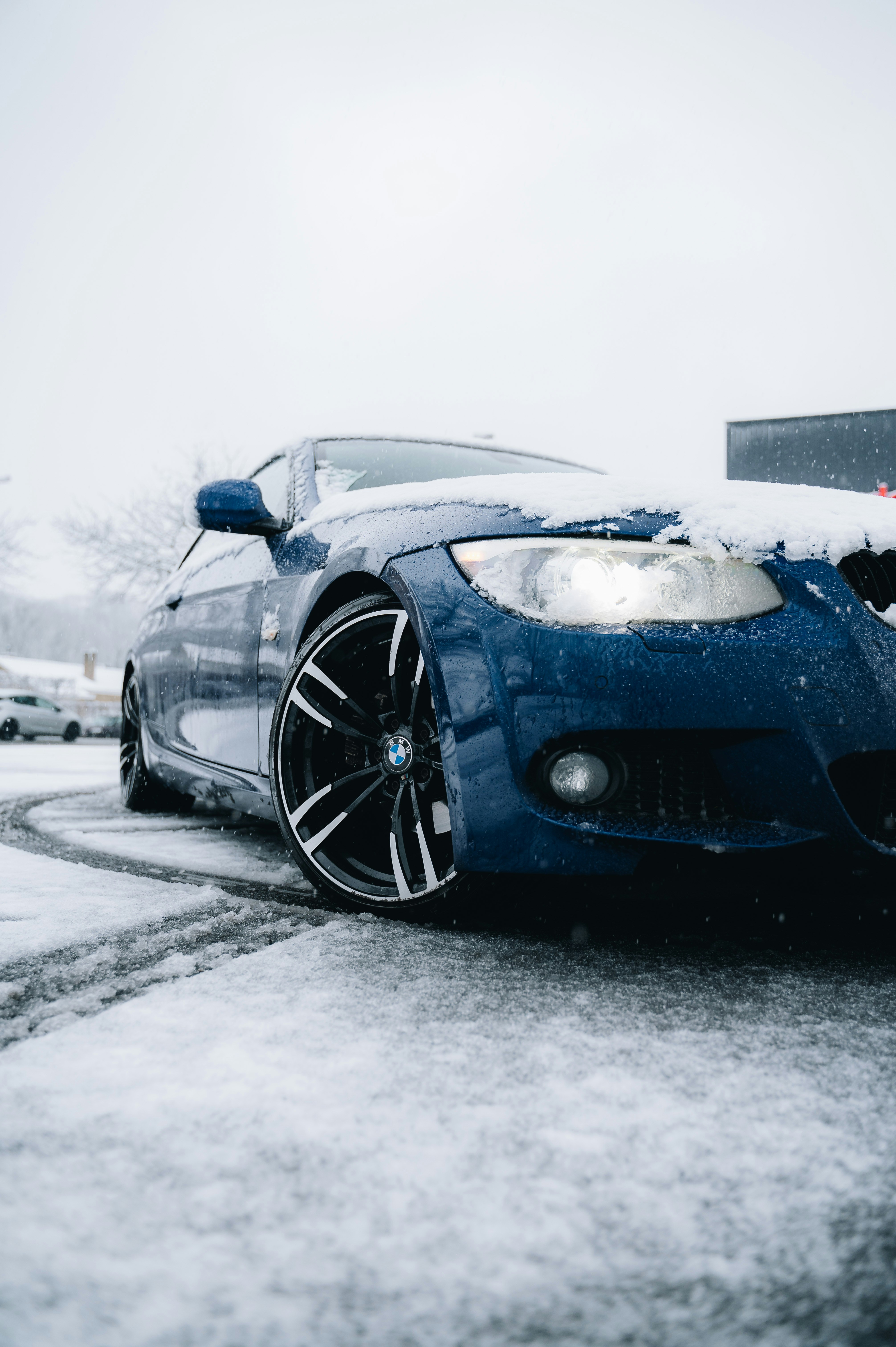 Snowbound Blue BMW: a low-angle close-up on a snow-kissed wheel
