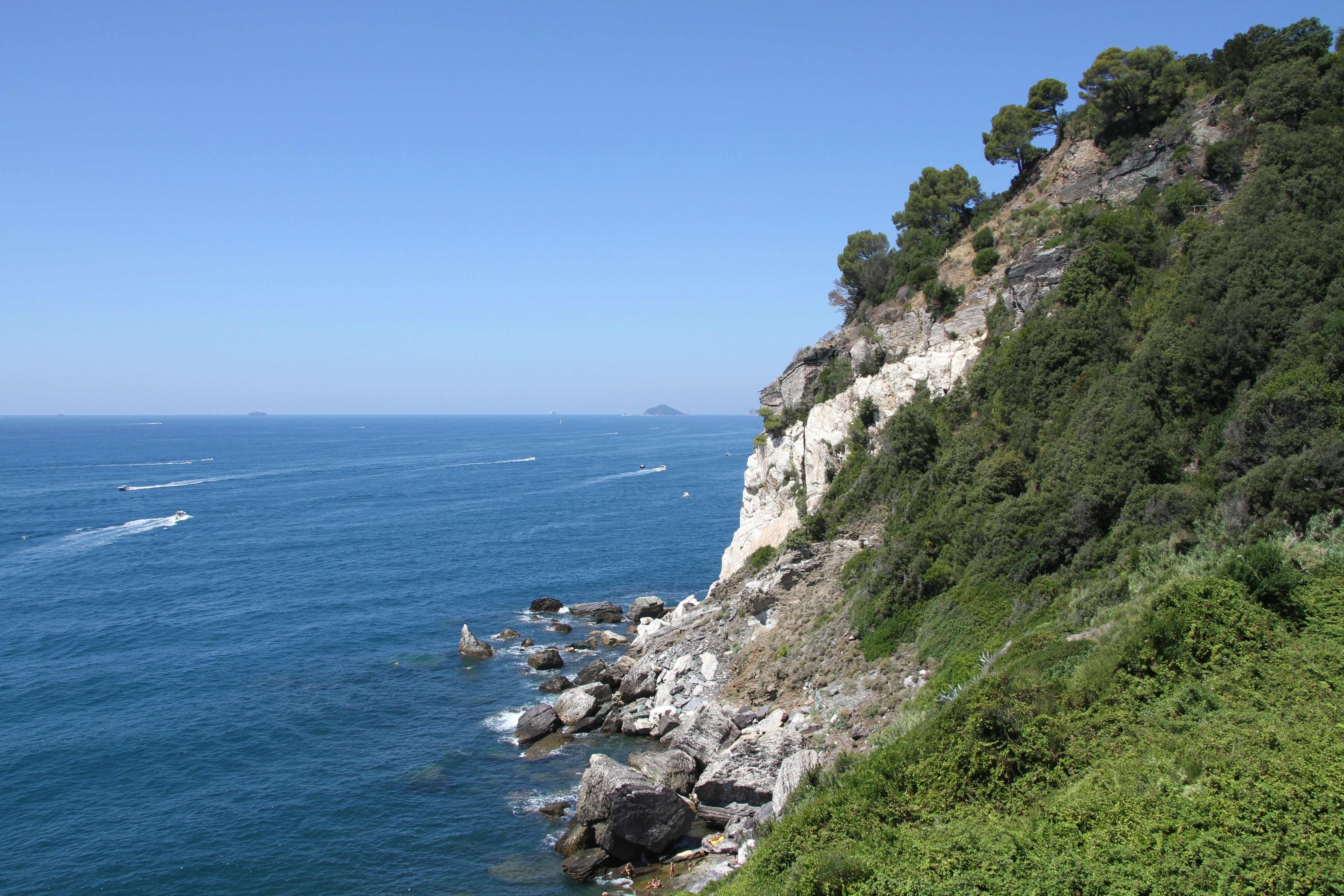 A boat is on the water near a cliff photo – Free Nature Image on Unsplash