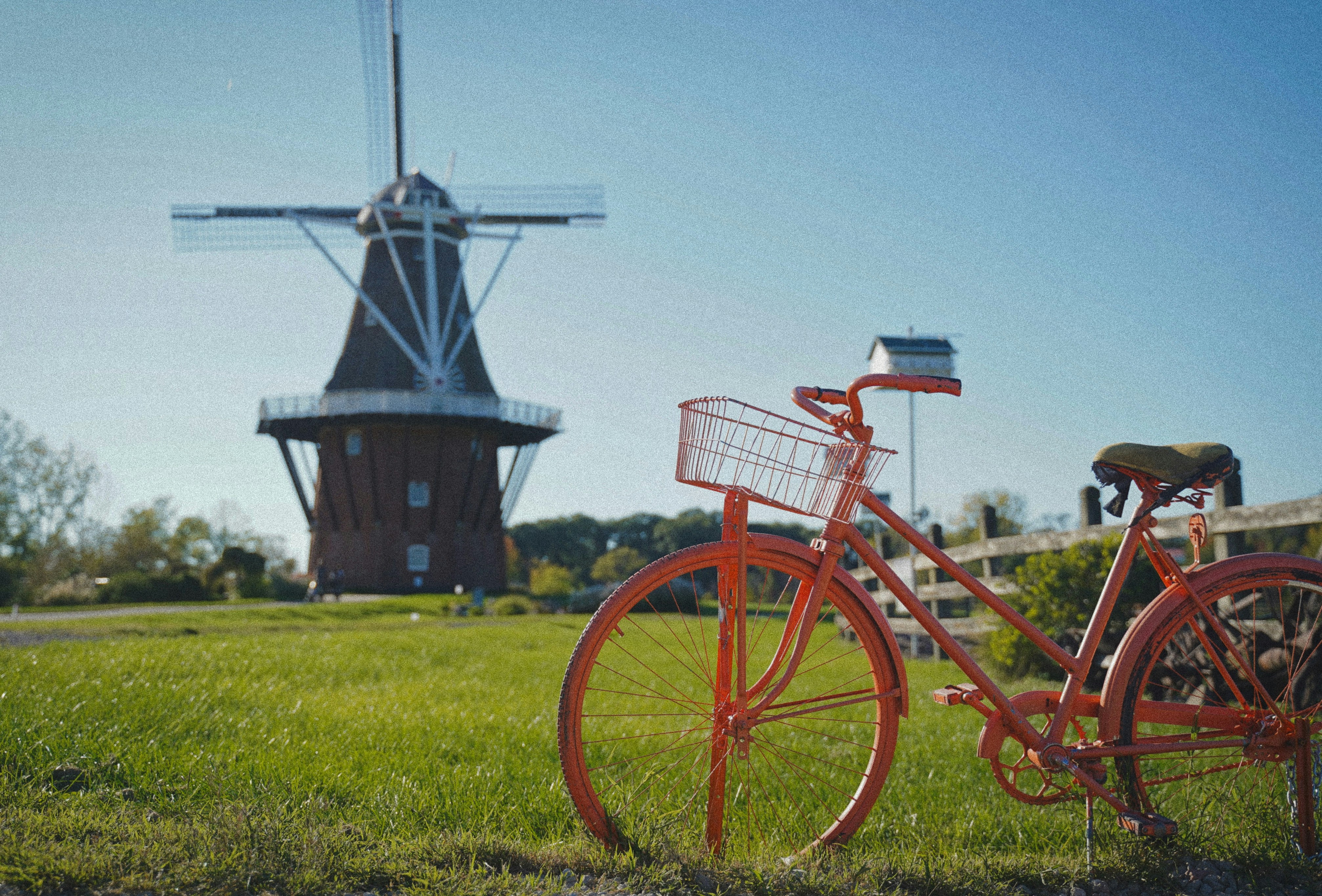 Crimson Bicycle by the Dutch Windmill in Quiet Daylight