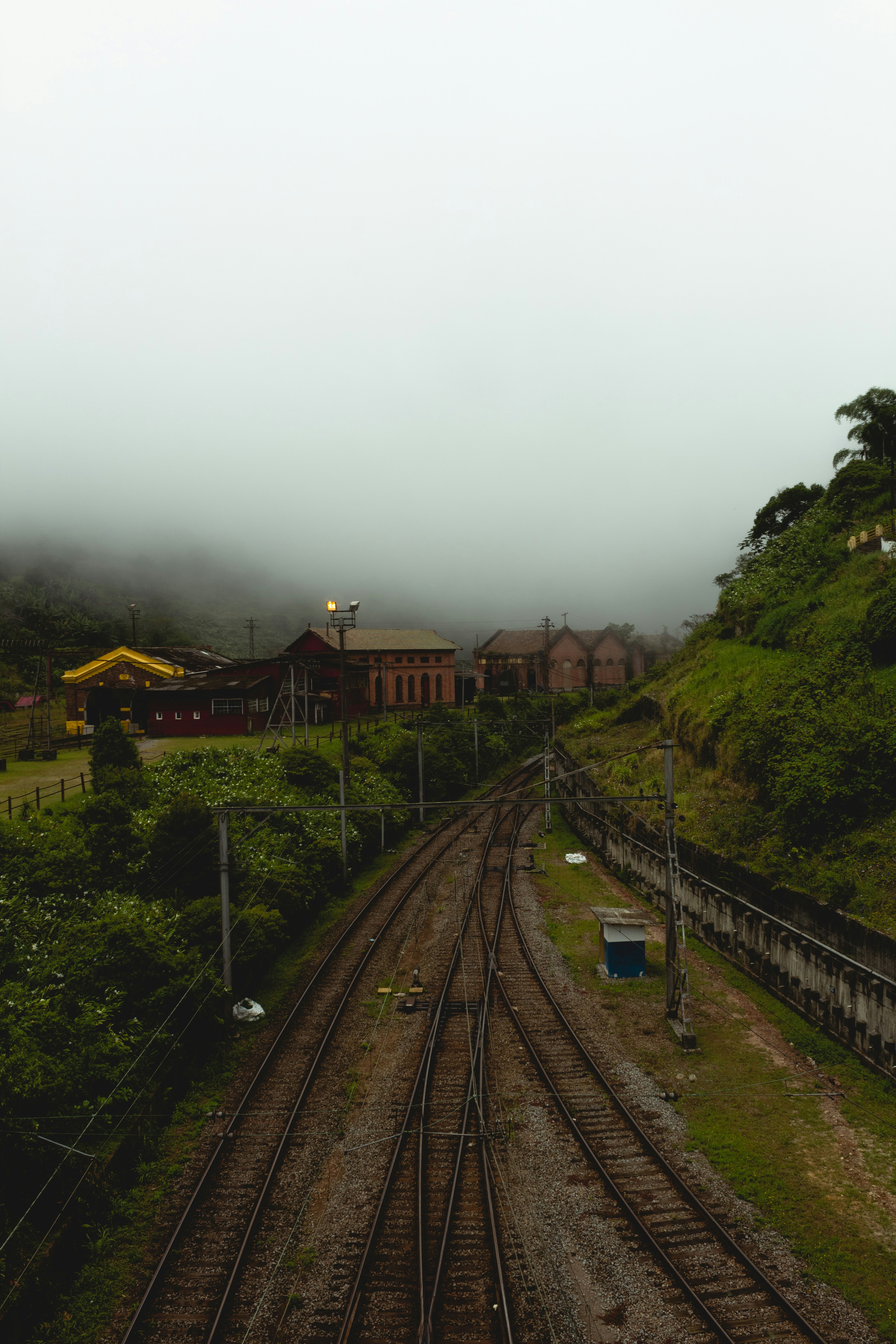 A train track with a train station in the background photo – Free Train ...