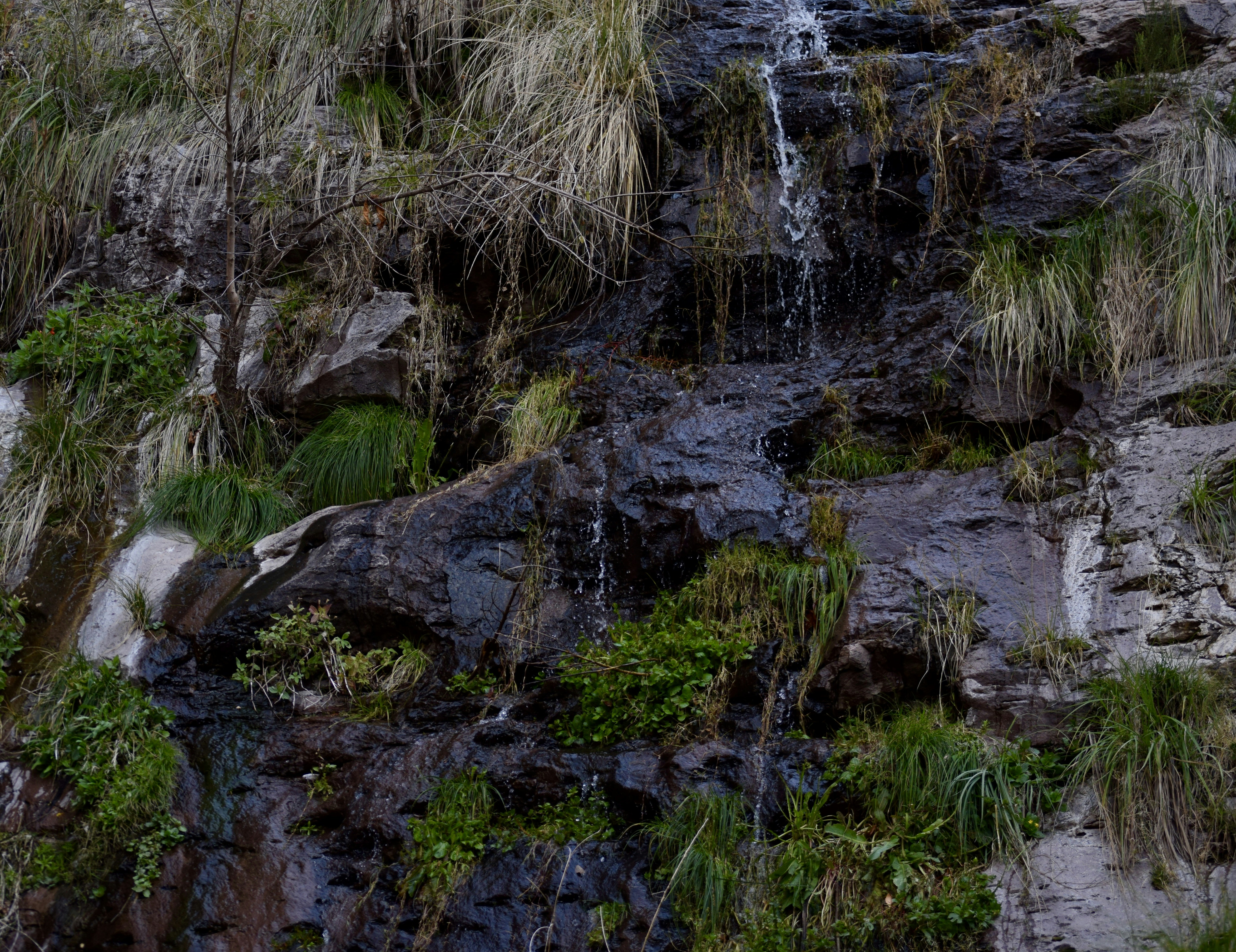 a waterfall with water cascading down it's side