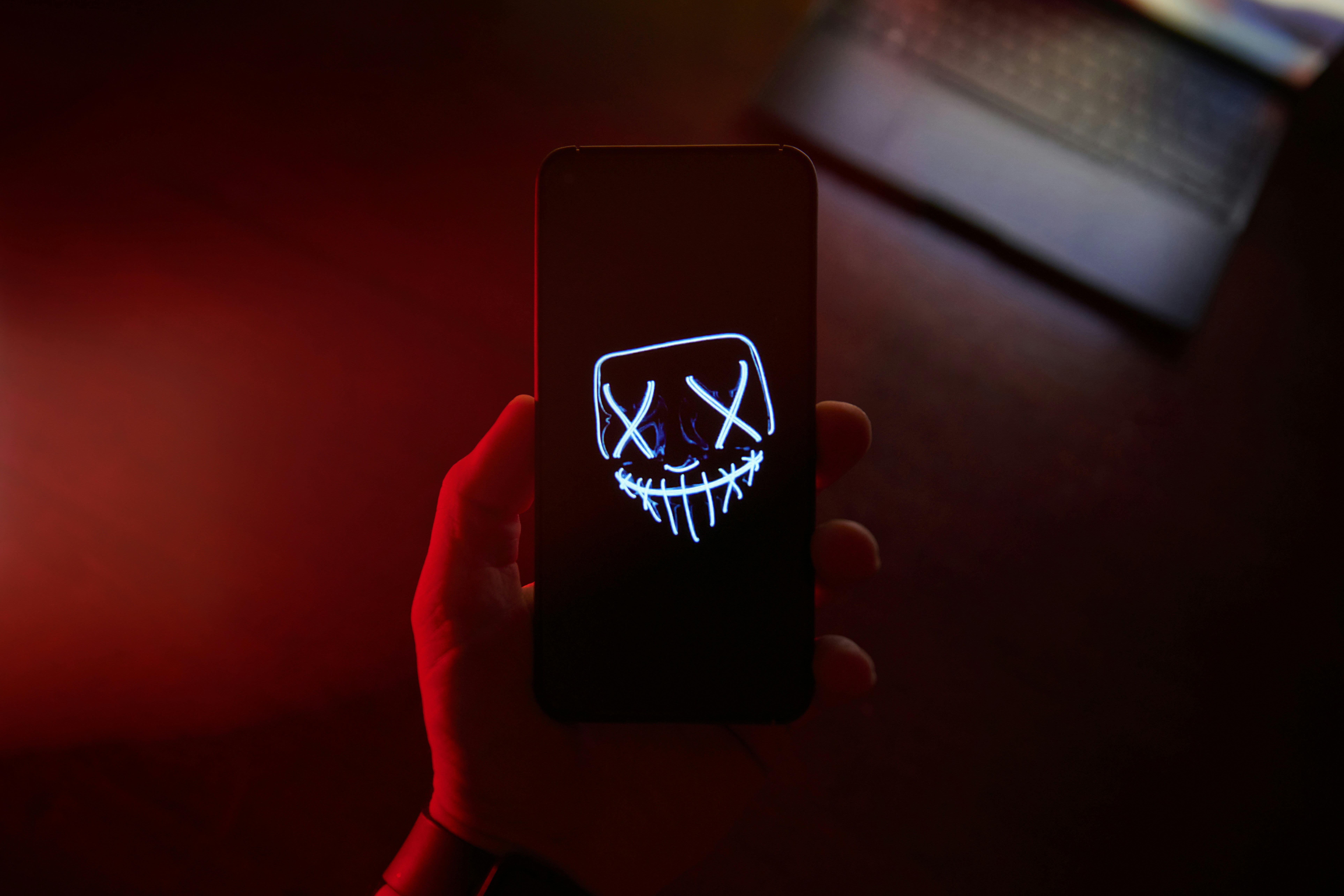A person holding a cell phone with a scary face on it photo – Free ...