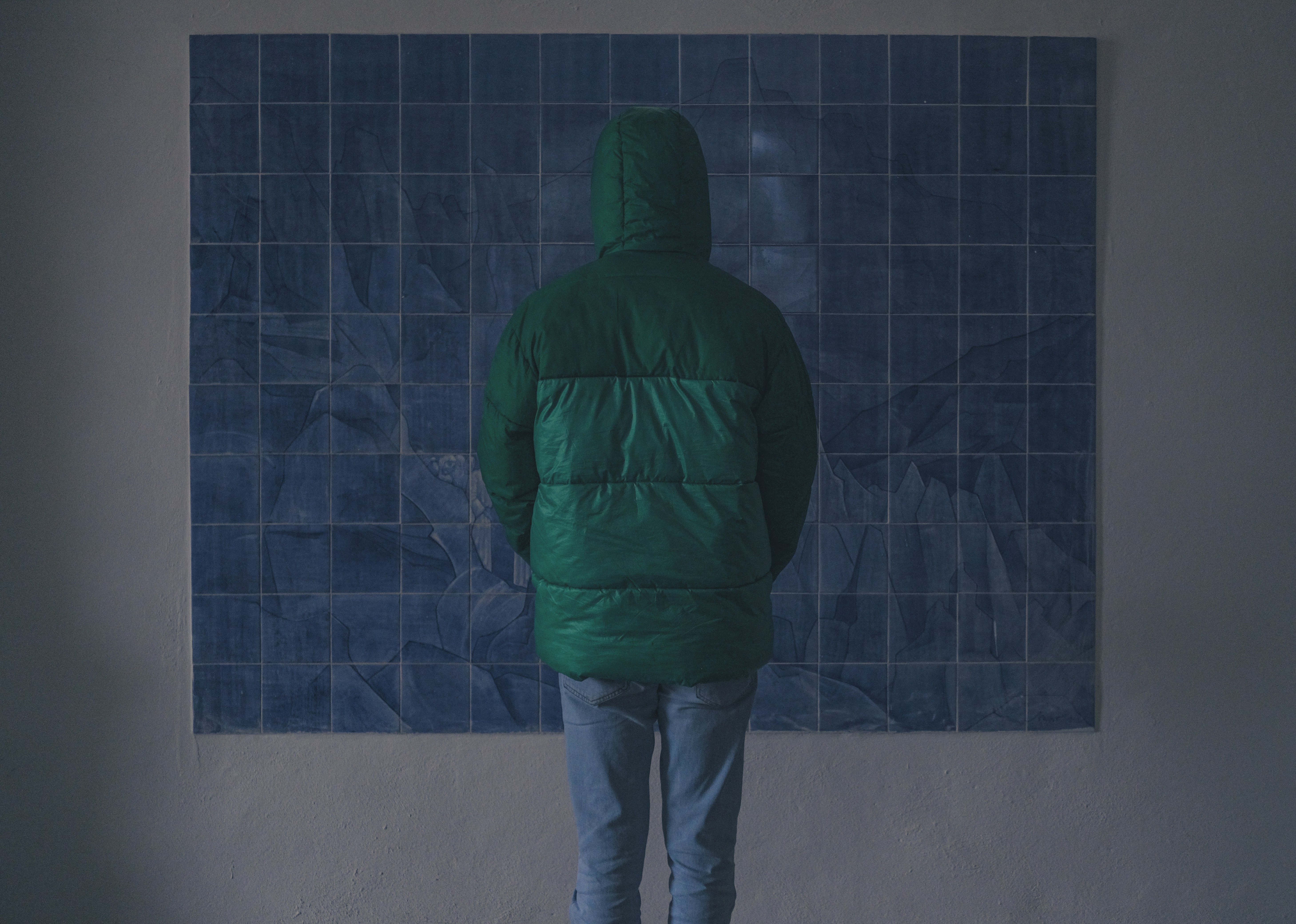 Una persona parada frente a una pared de azulejos azules foto – Imagen ...