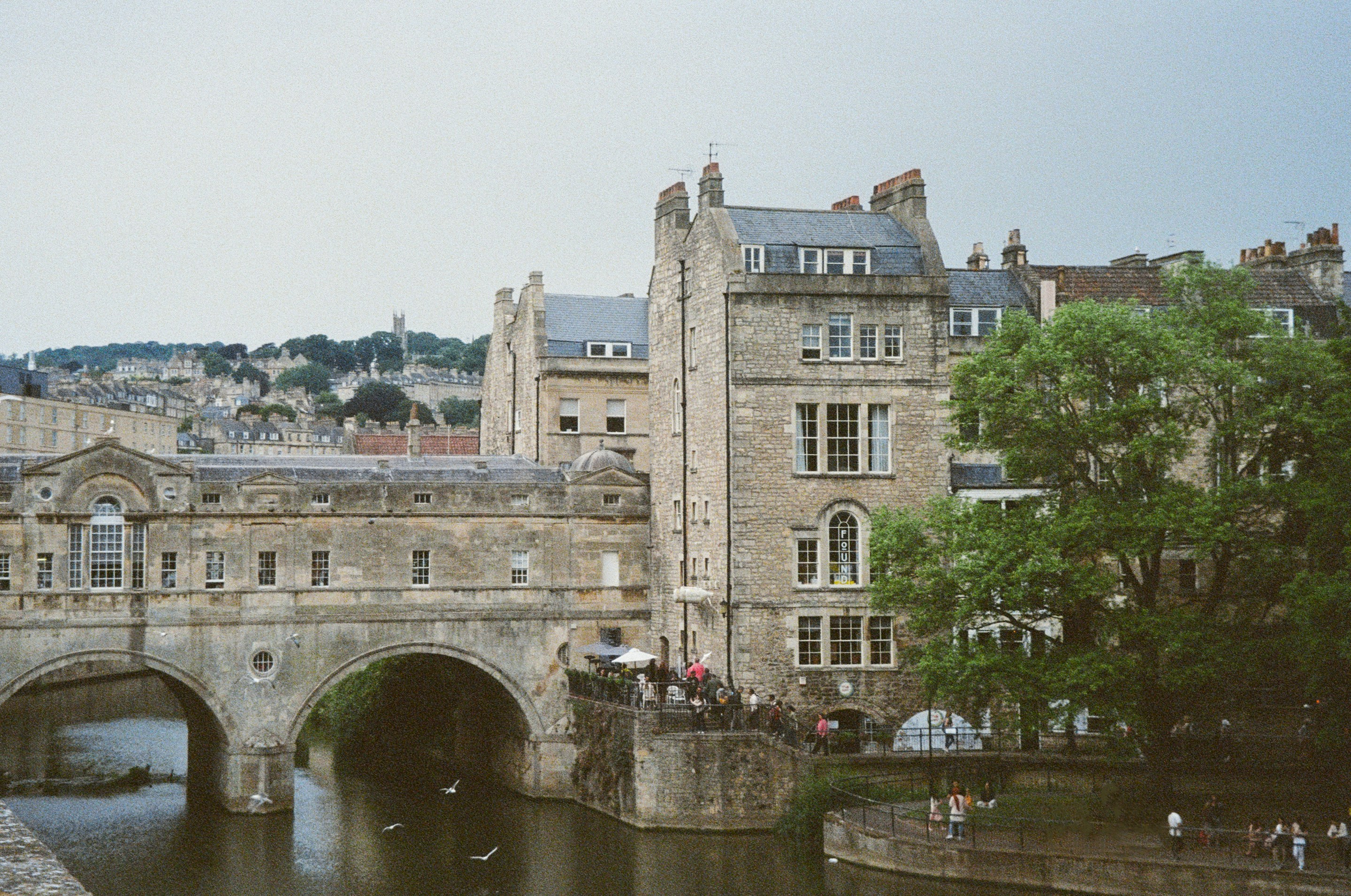 A bridge over a body of water with buildings in the background photo ...