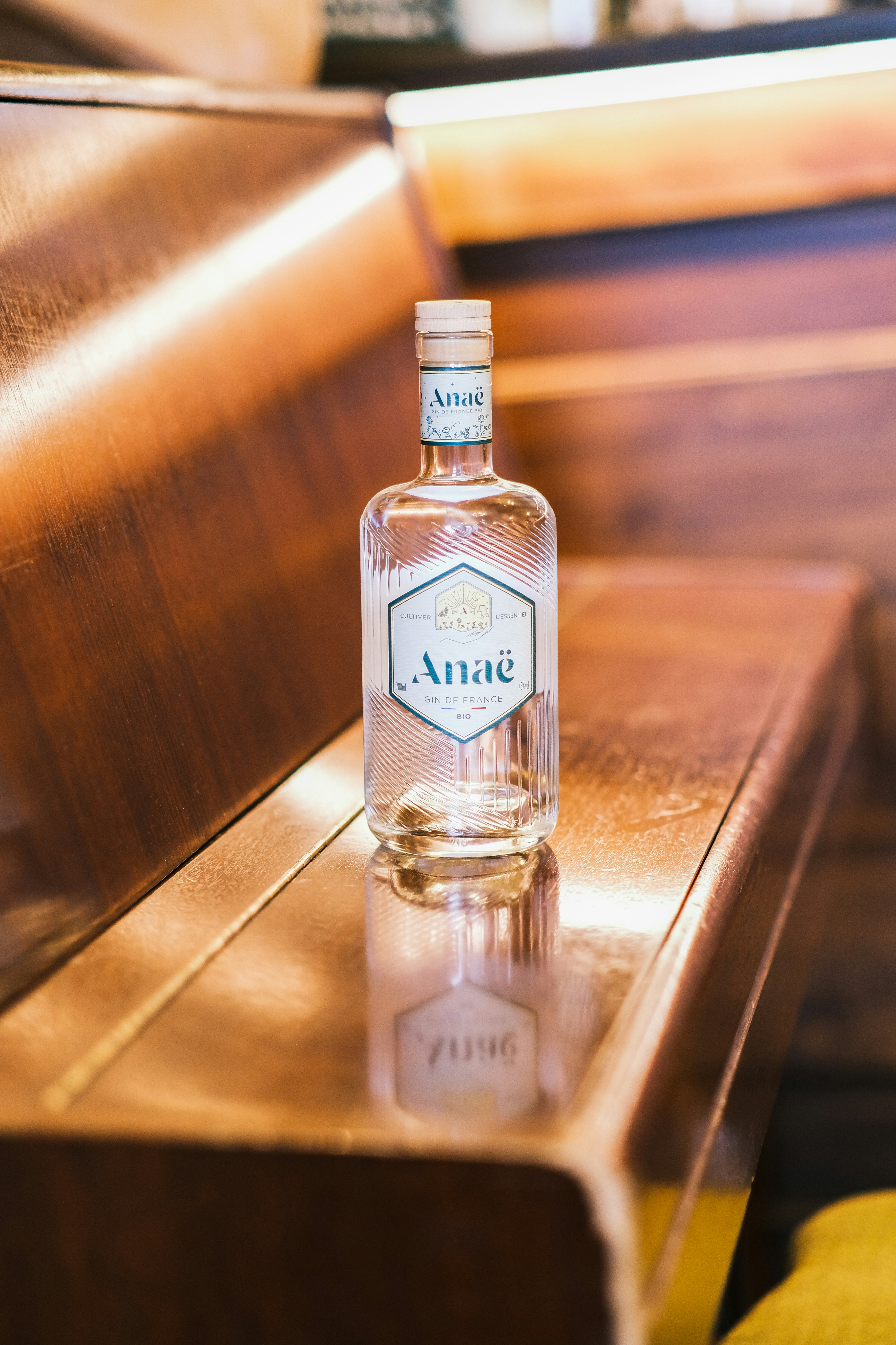 A bottle of alcohol sitting on a bench photo – Free Gin Image on Unsplash