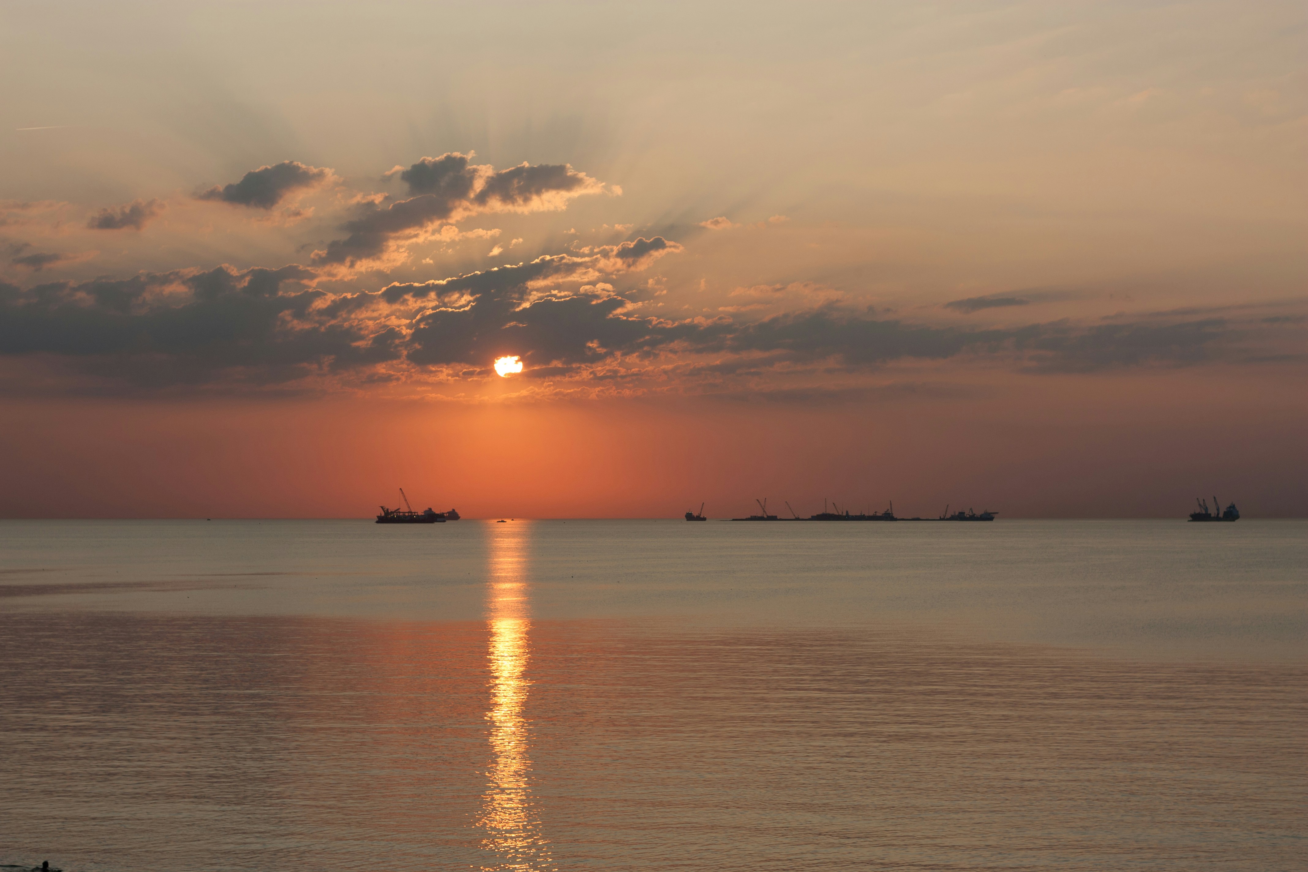 Dusk's Quiet Fleet: Sunset Over a Calm Sea