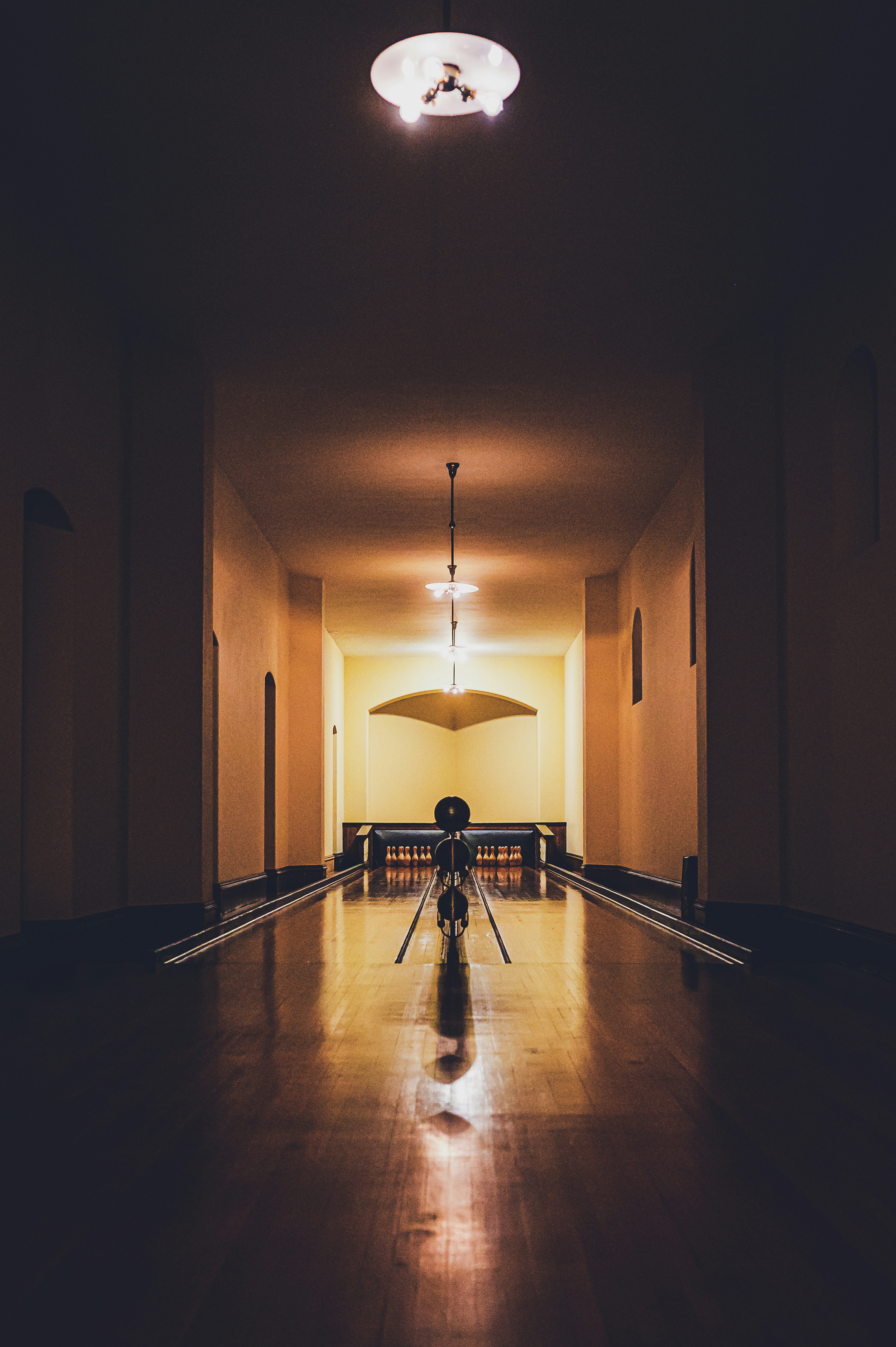End of the Hall: A solitary tripod anchors a warmly lit corridor