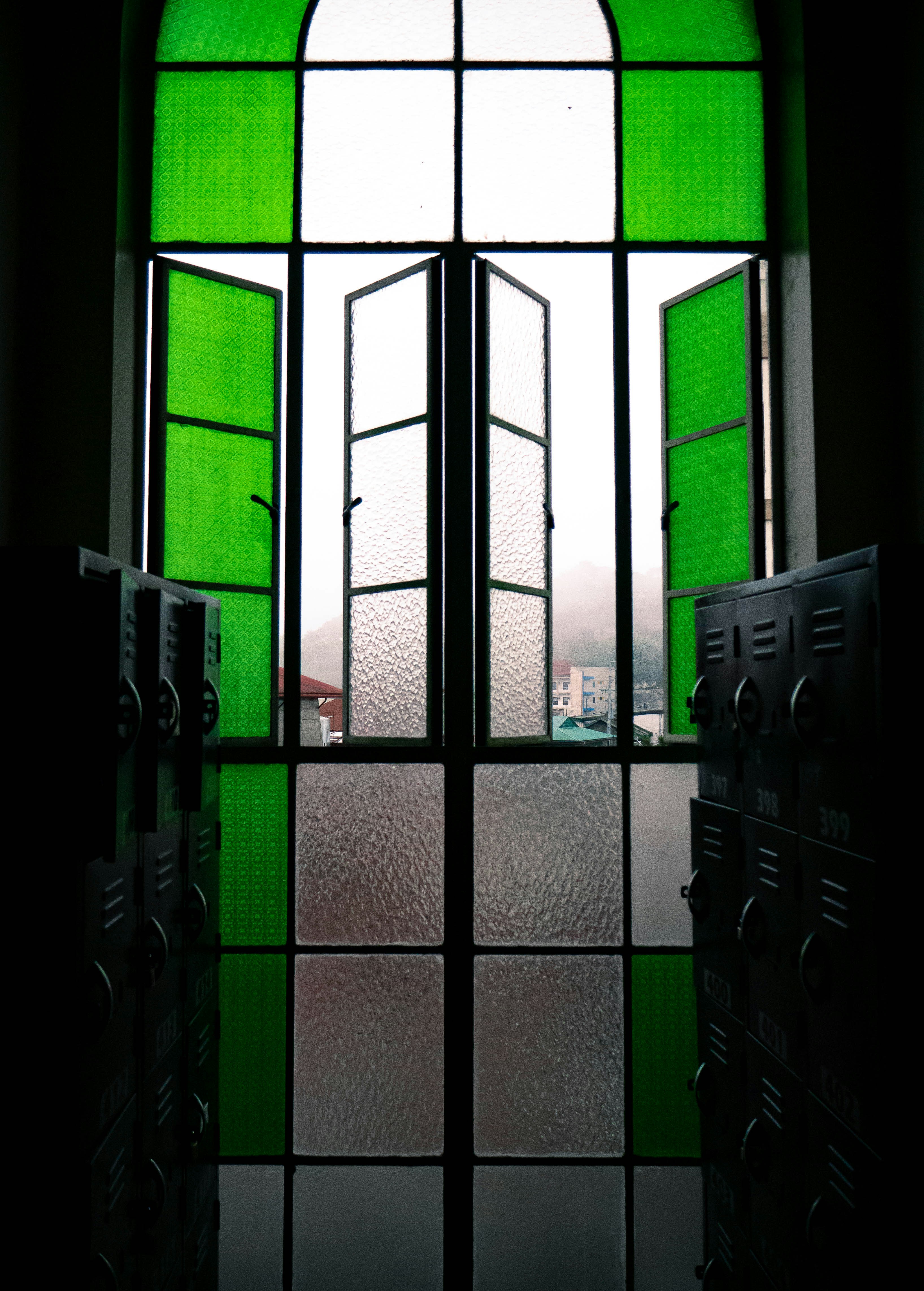 Emerald Archway: Light Breaks Through a Locker Corridor