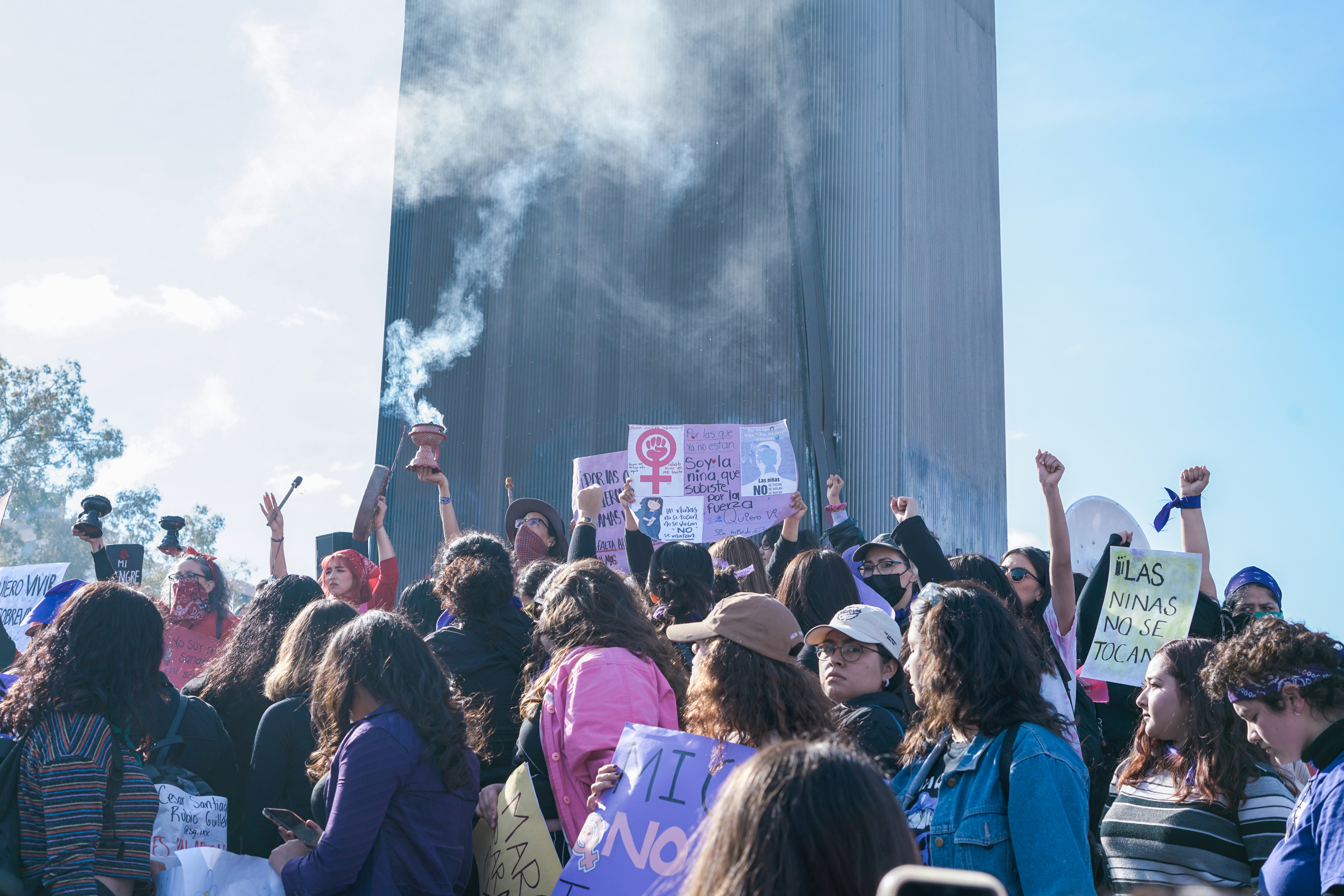 A large group of people holding signs in front of a building photo ...