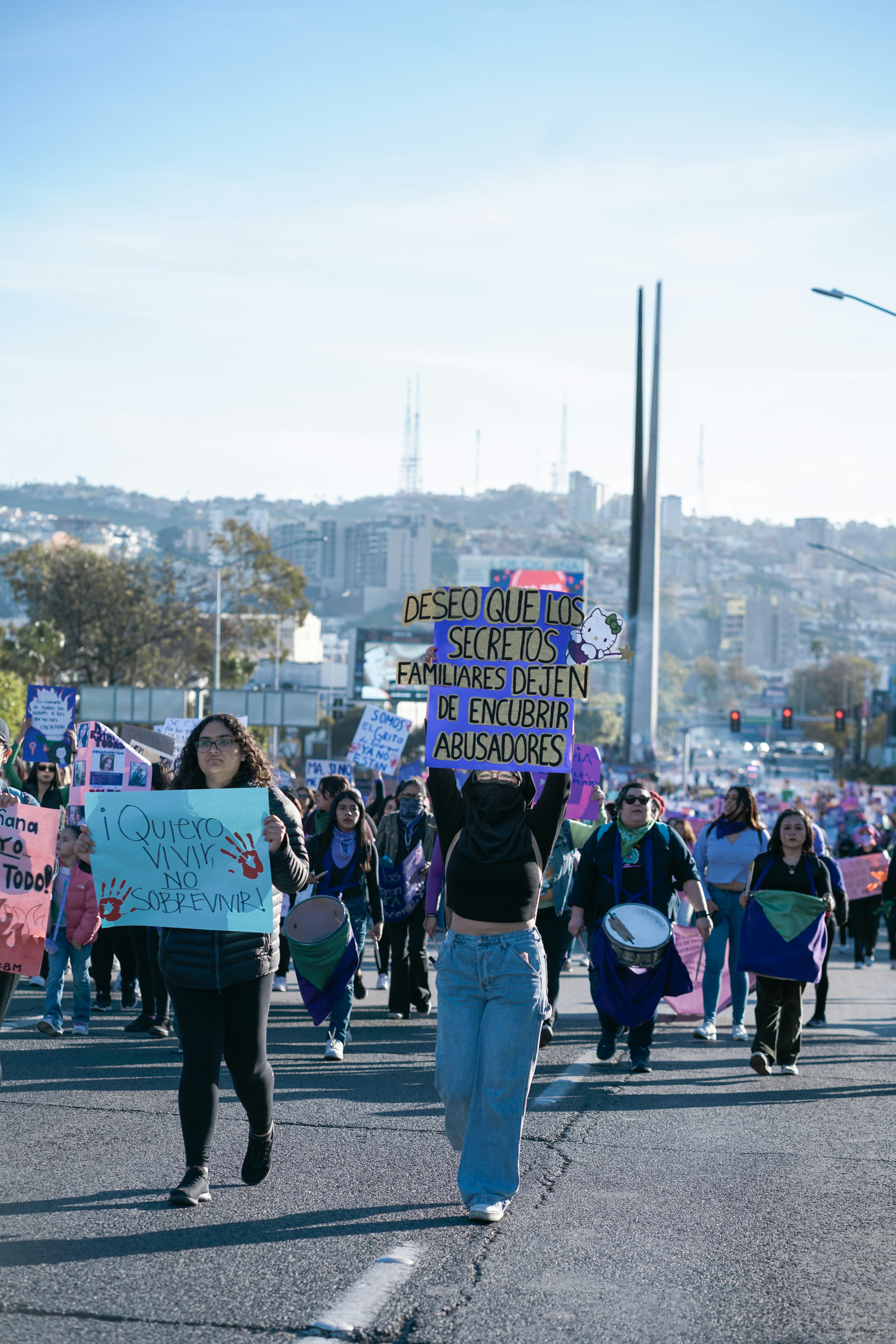 A group of people walking down a street holding signs photo – Free ...