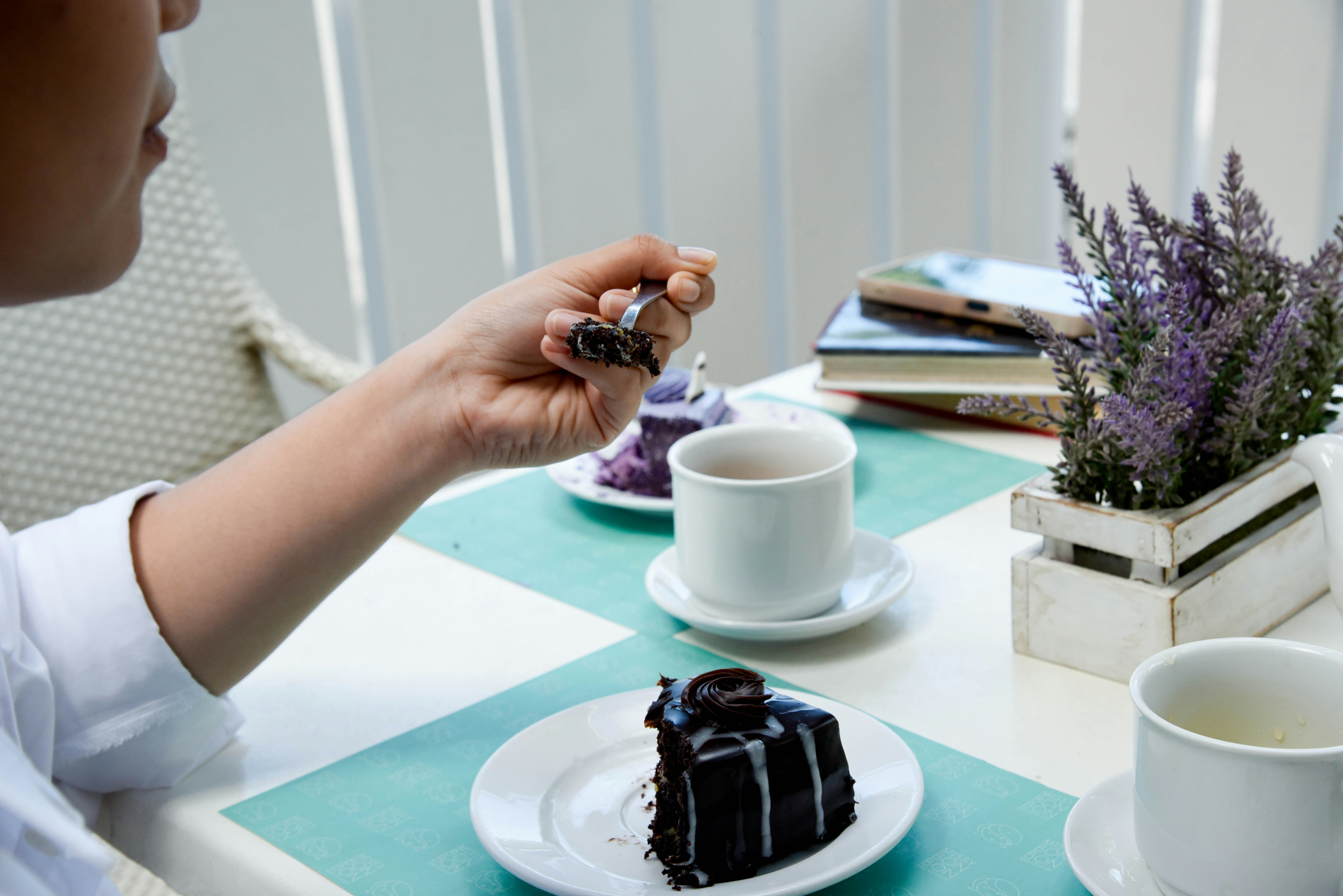 A quiet moment of sweetness: half-eaten chocolate cake and a hand poised with a fork