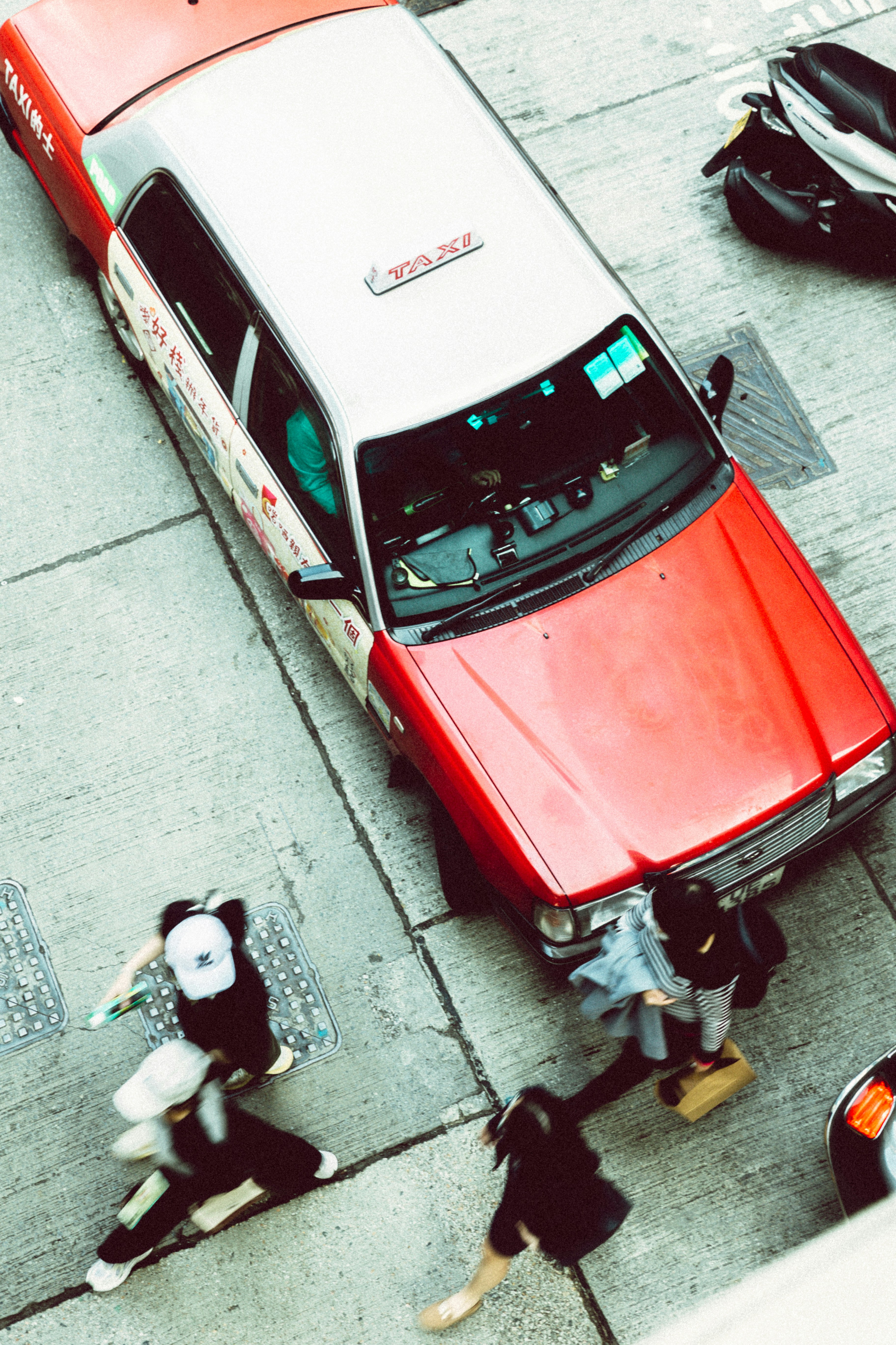 Crimson Taxi Cutting Through a Concrete Grid: An Aerial Street Moment