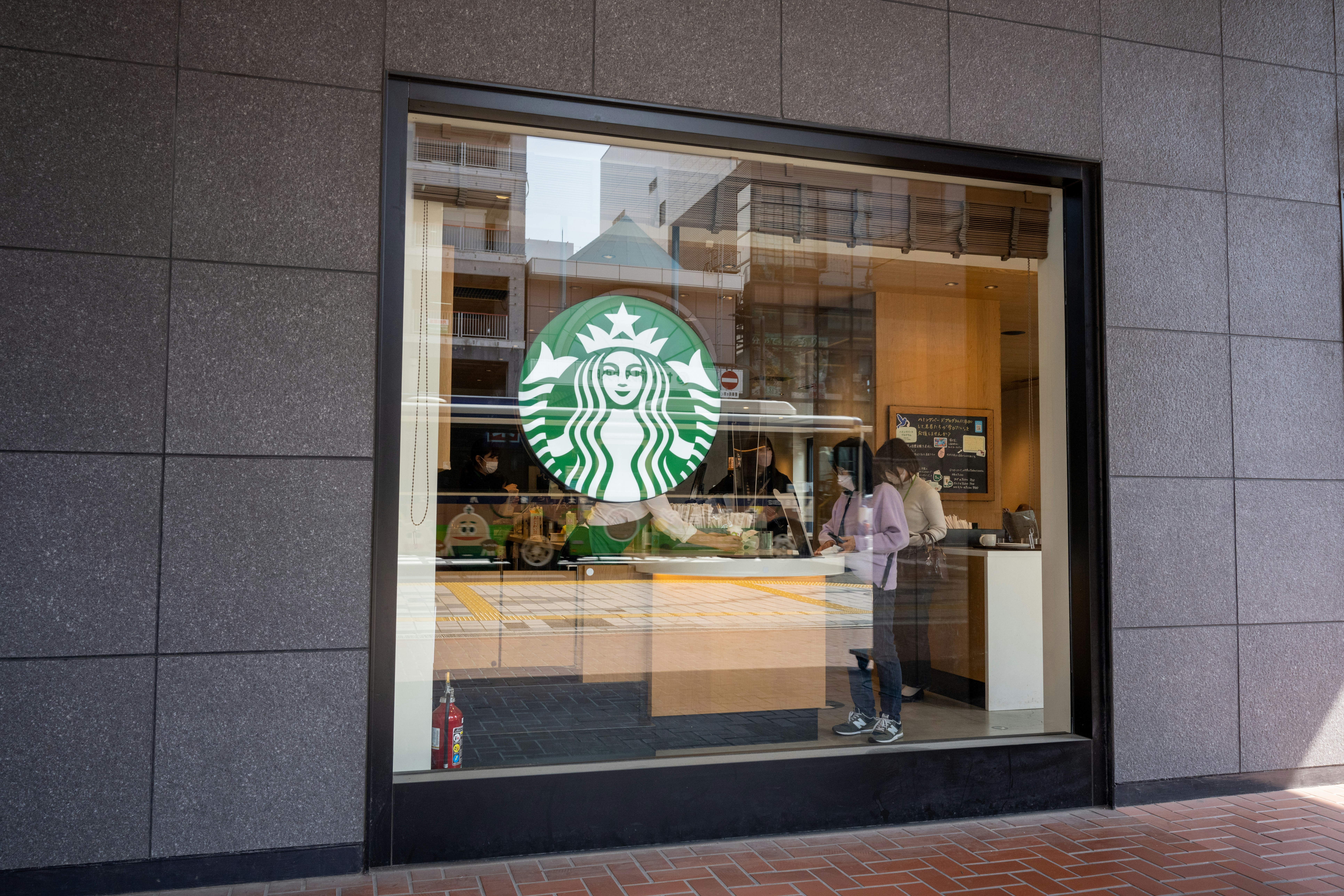 A starbucks coffee shop with a man standing in the window photo – Free ...