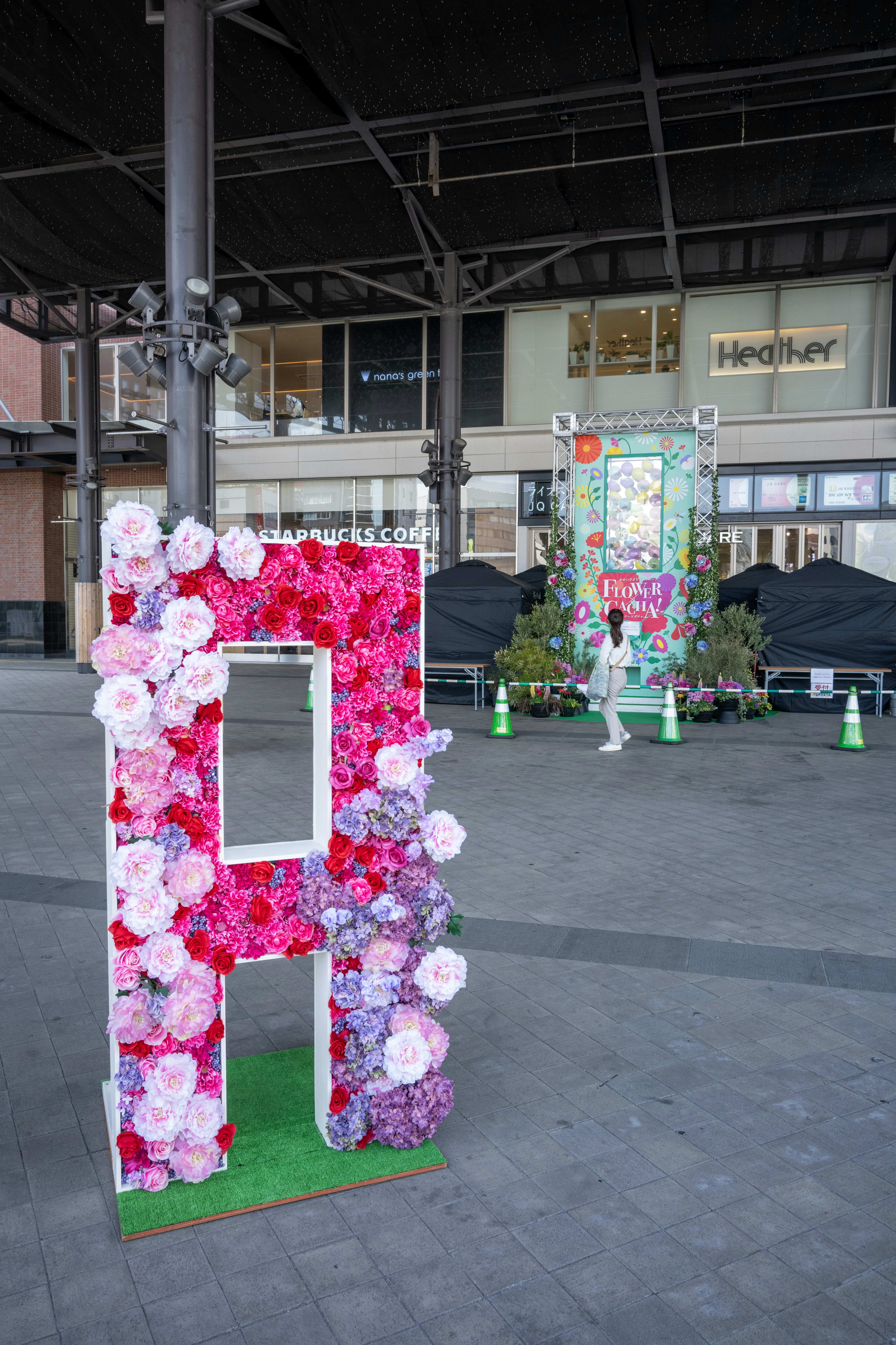 a large letter made out of flowers in a parking lot