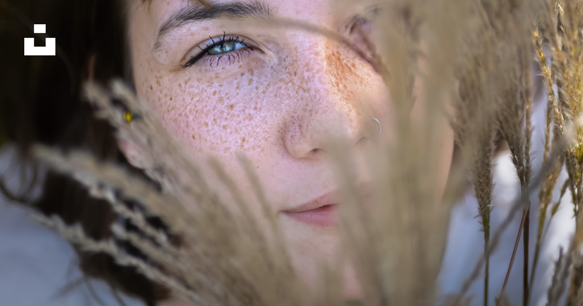 Foto Una Mujer Con Pecas En La Cara Se Esconde Detrás De Una Hierba