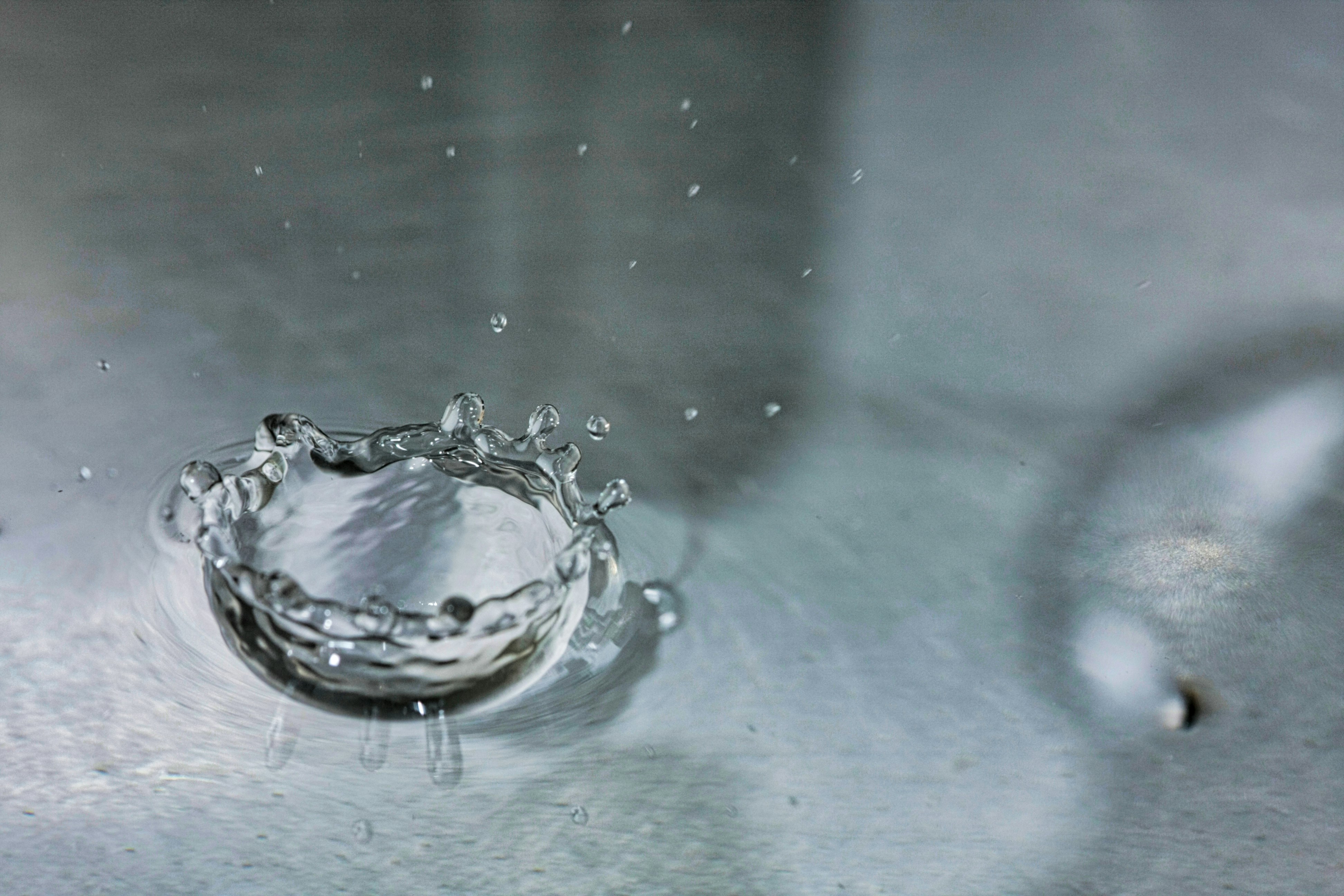 A crown-shaped splash of water captured mid-air against a reflective surface, showcasing the intricate patterns formed by the impact.