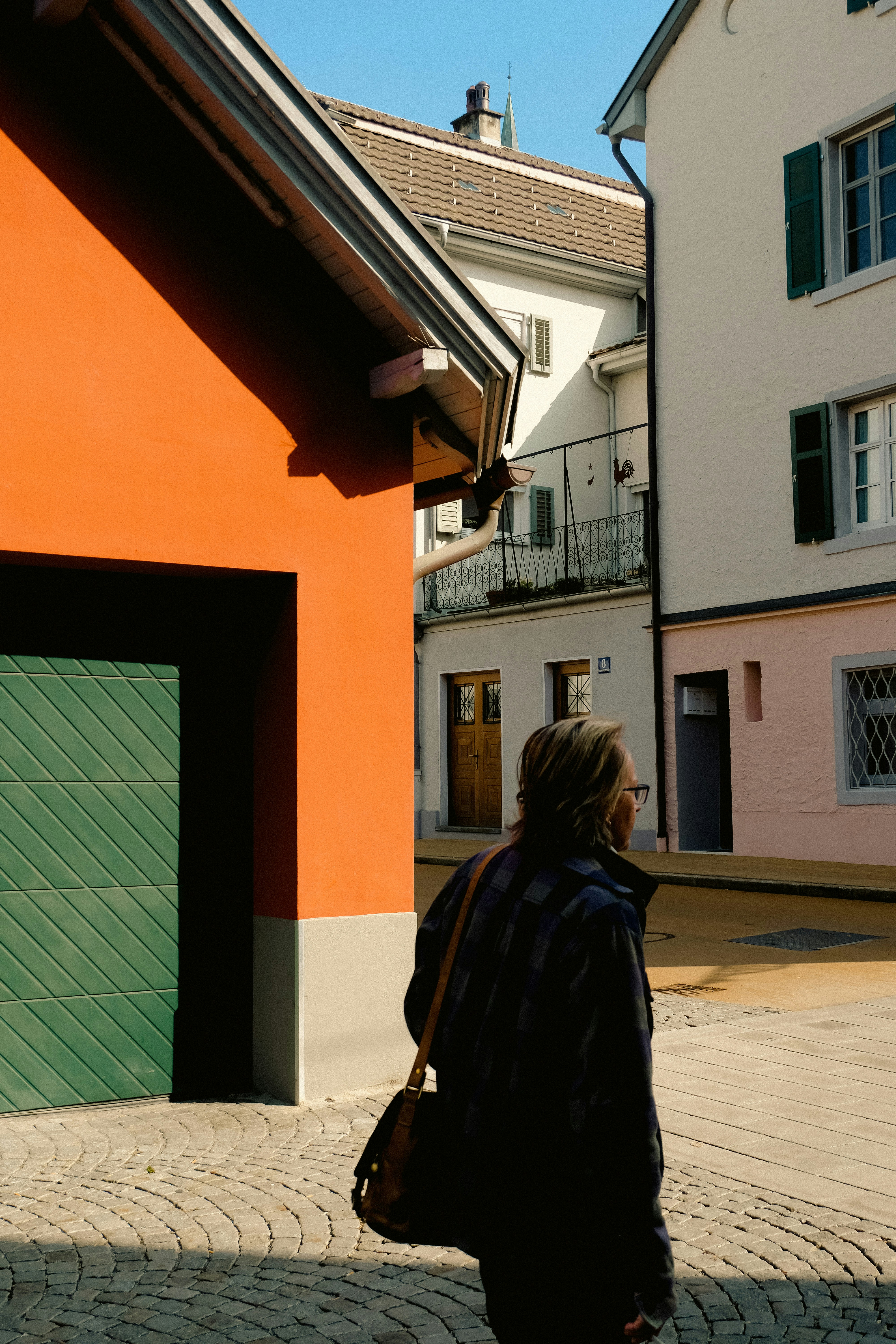 Painted Facades, Quiet Steps: A Solo Traveler in a Sunlit Street