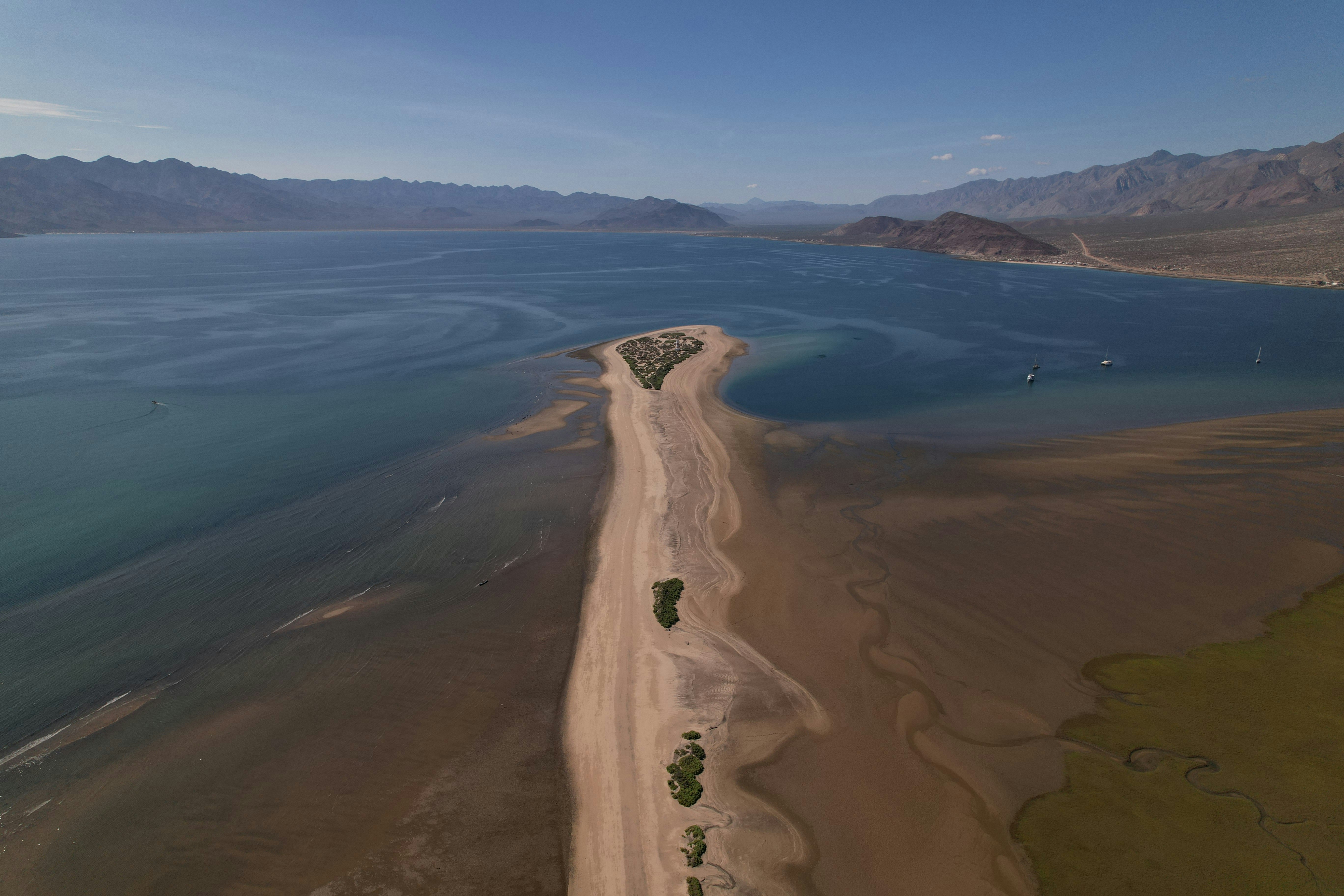 Sandbar Beacon: A Narrow Spit Connecting Lagoons Beneath Desert Peaks