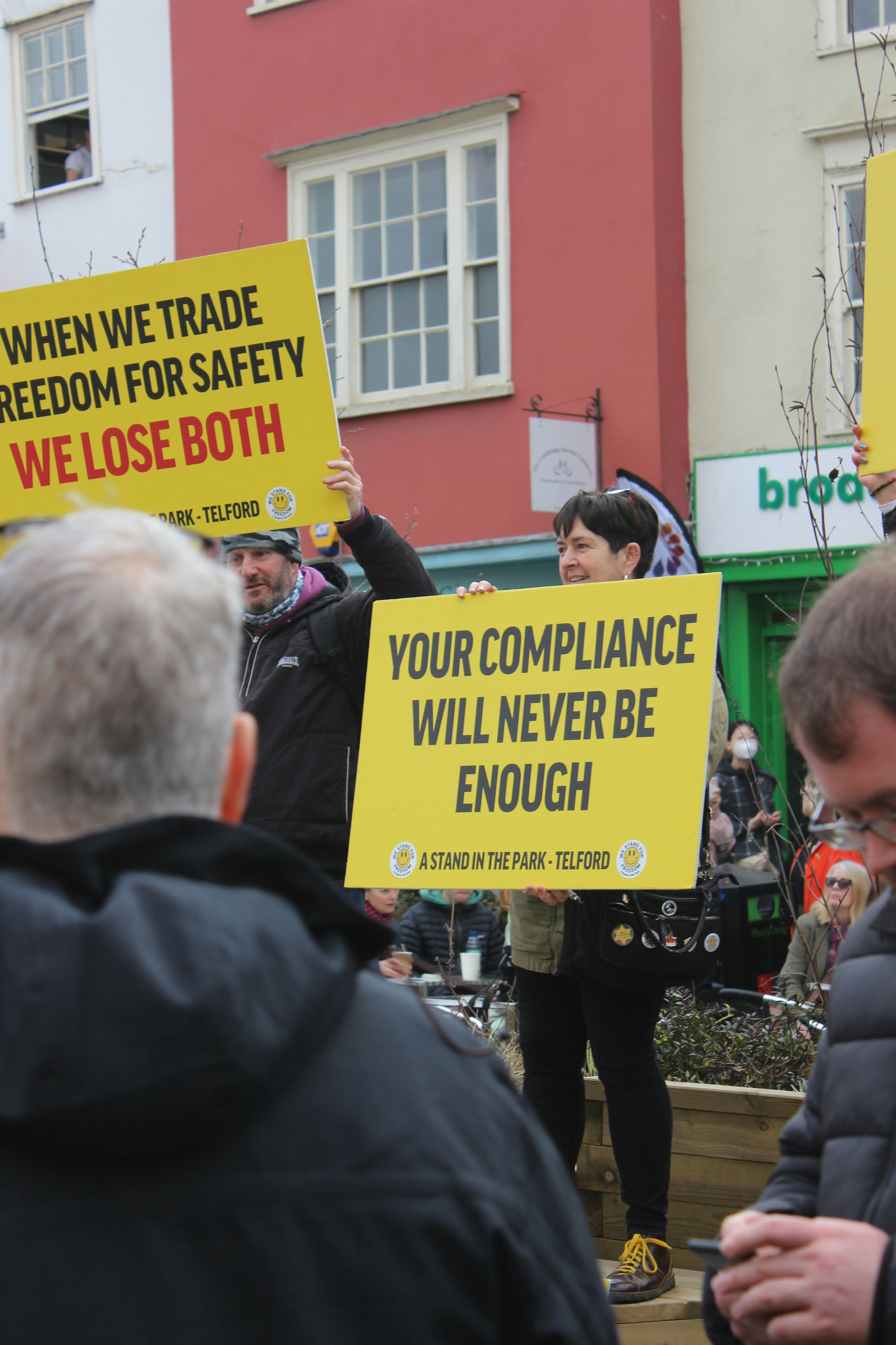 Yellow Sign Refrain: Protesters with Bold Messages in a City Square