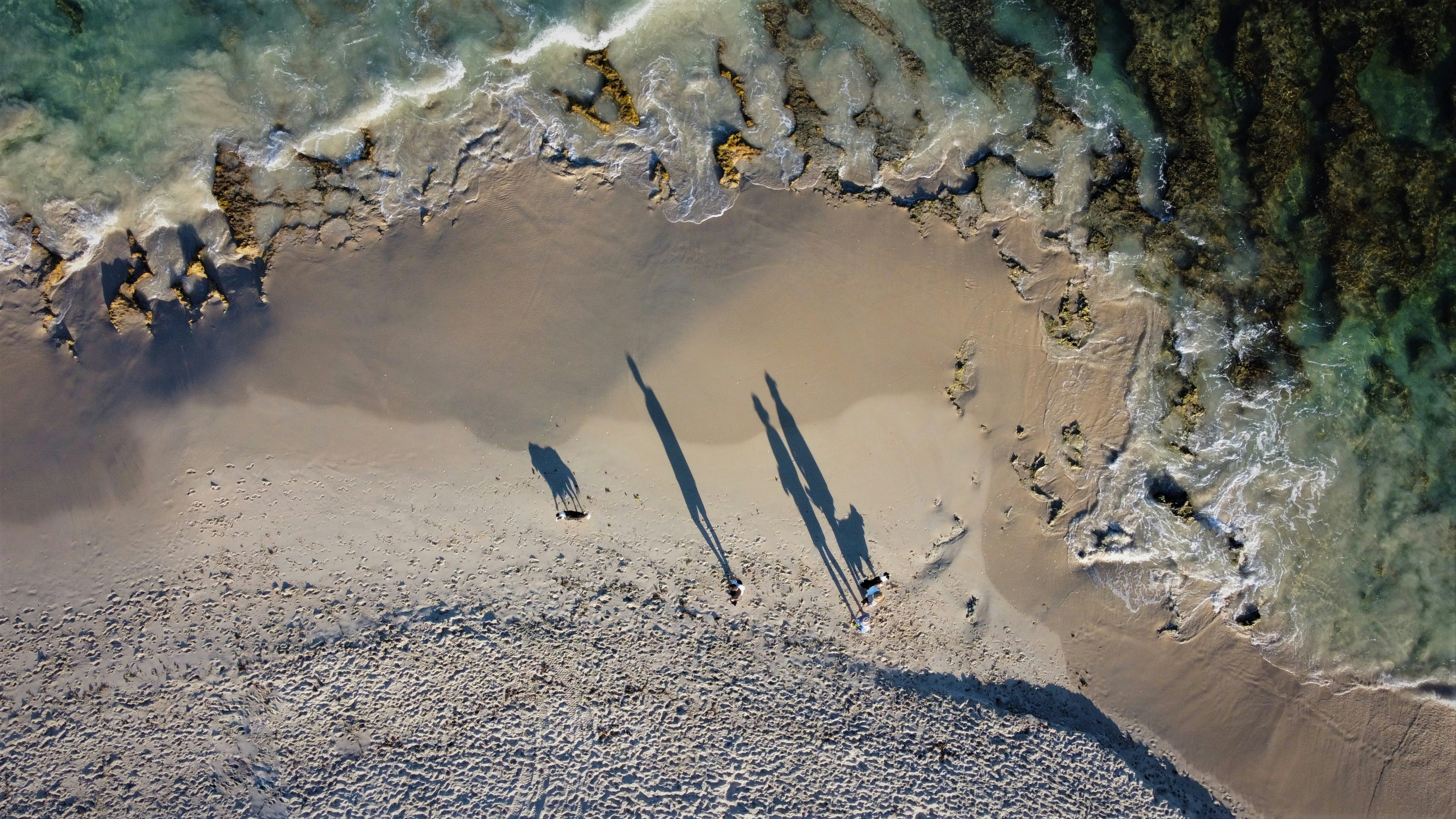 Shadow Lines Across a Turquoise Shore: Long Boat Silhouettes