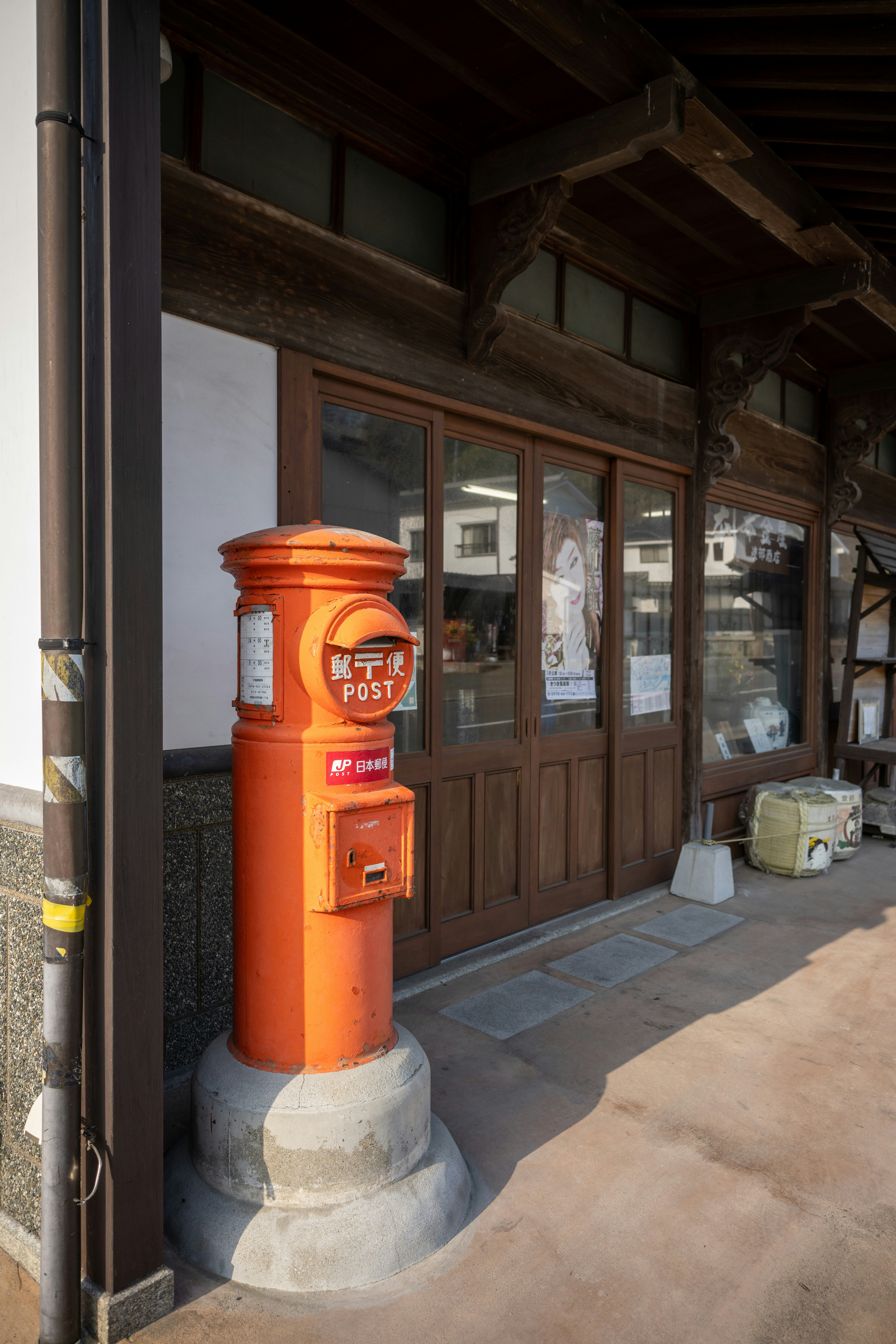 Orange Postbox at the Edge of a Traditional Japanese Facade