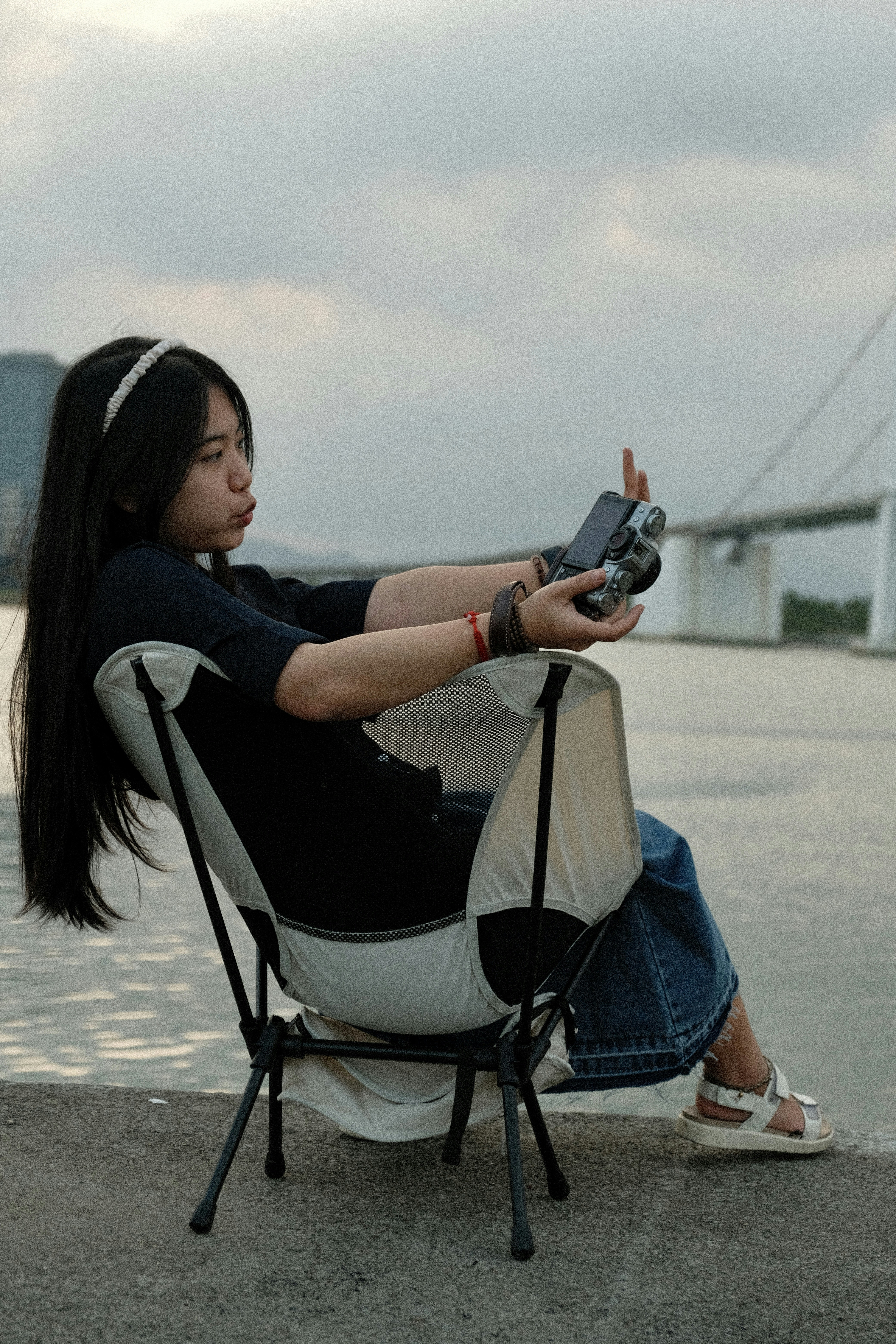 a woman sitting in a chair looking at her cell phone