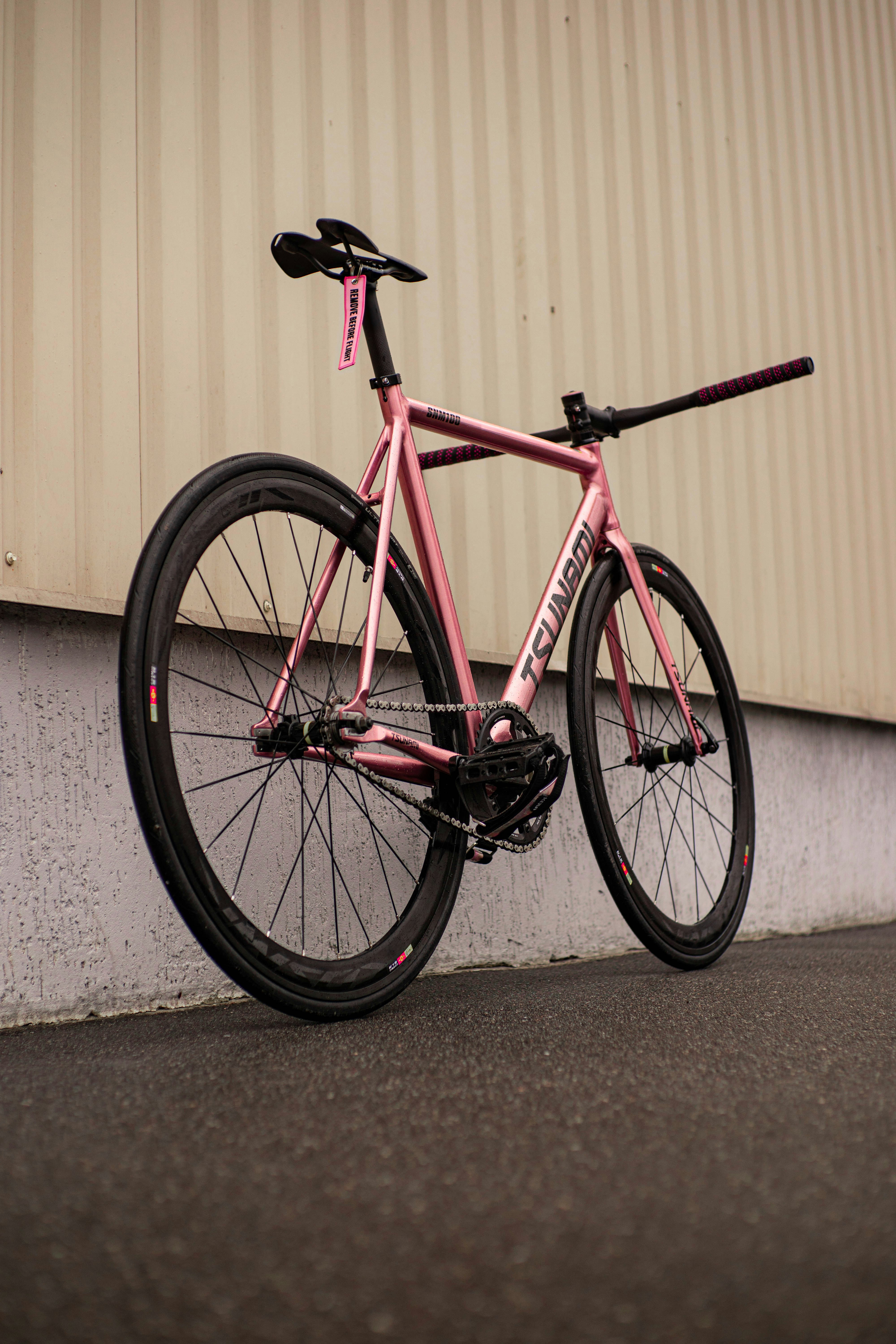 A pink bike parked next to a building photo – Free Tsunami snm100 Image ...