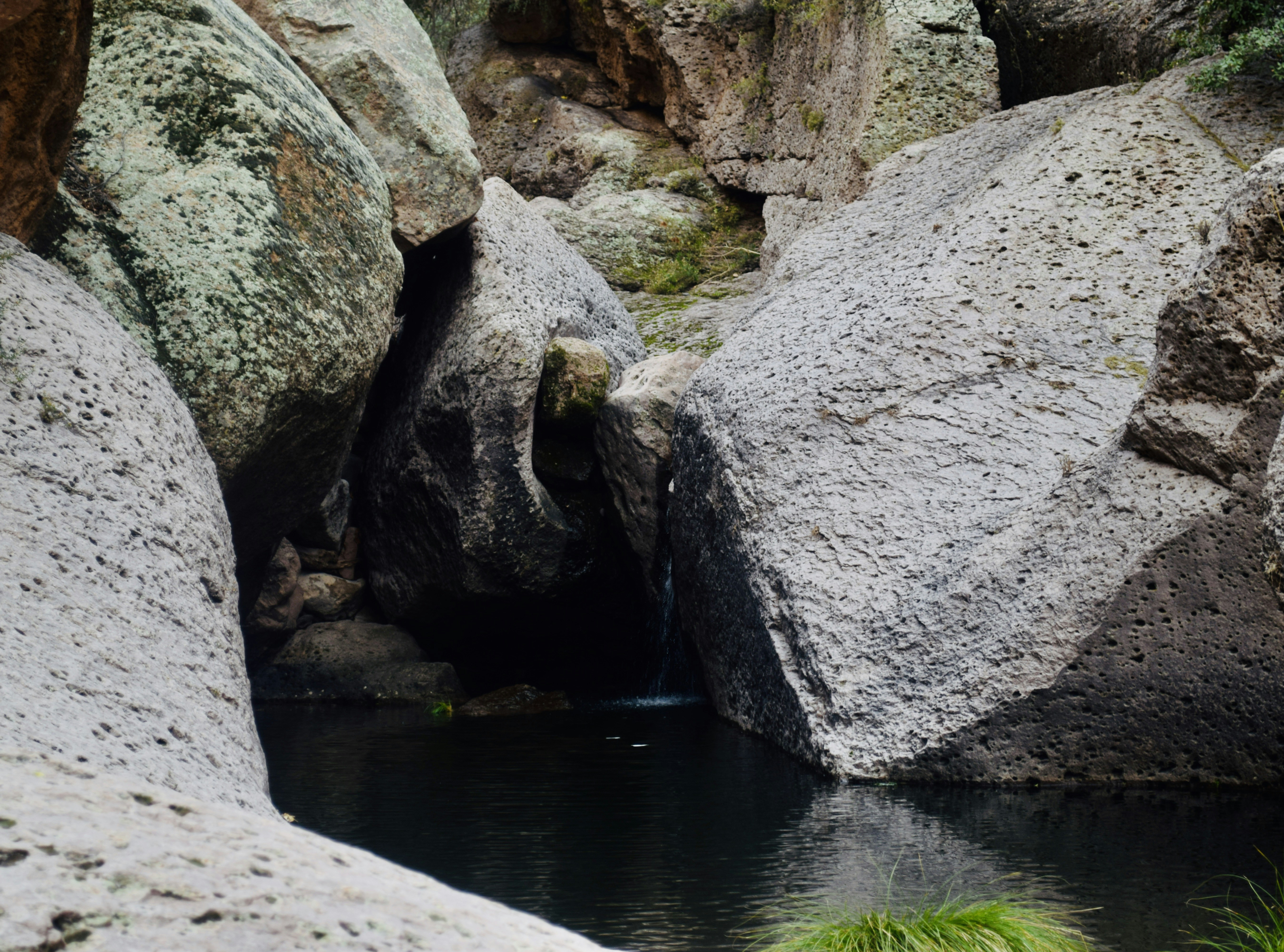 A small pool of water surrounded by large rocks photo – Free Wilderness ...