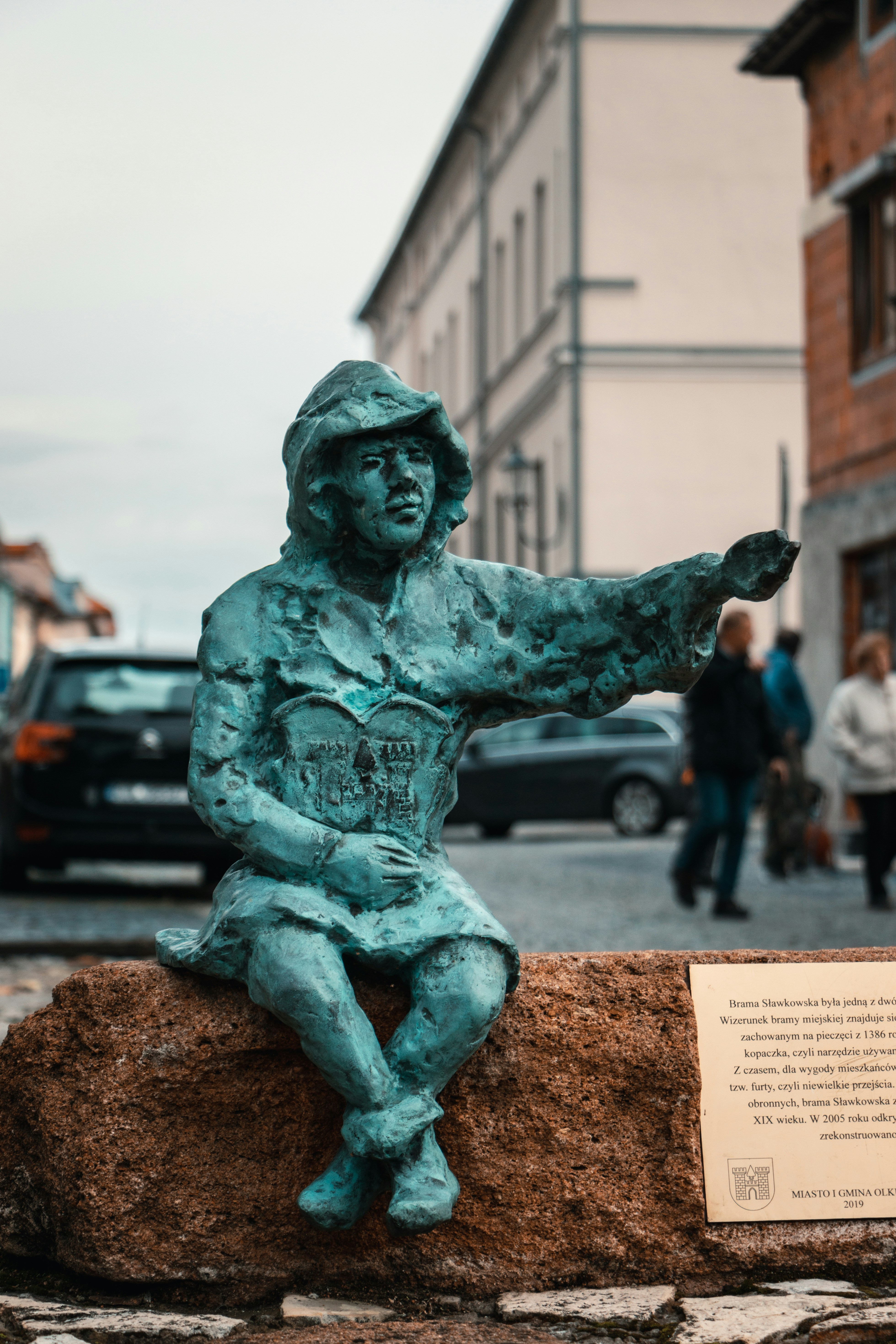The Reaching Figure: A Turquoise Patina Statue Anchoring a Quiet Town Square