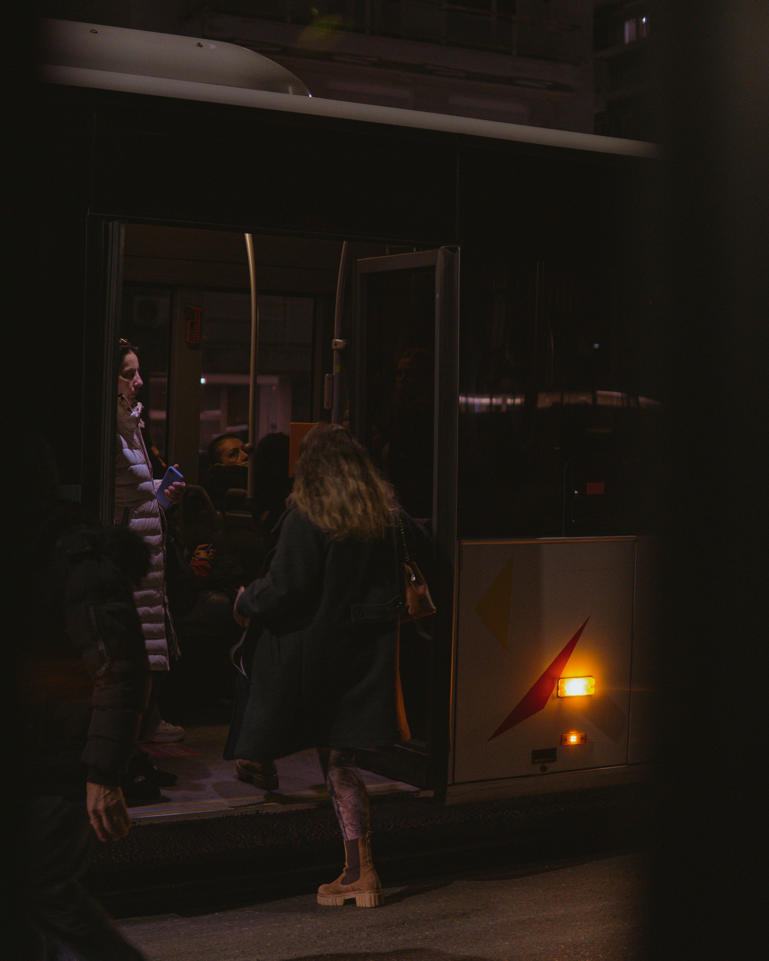A group of people boarding a bus at night photo – Free Woman Image on ...