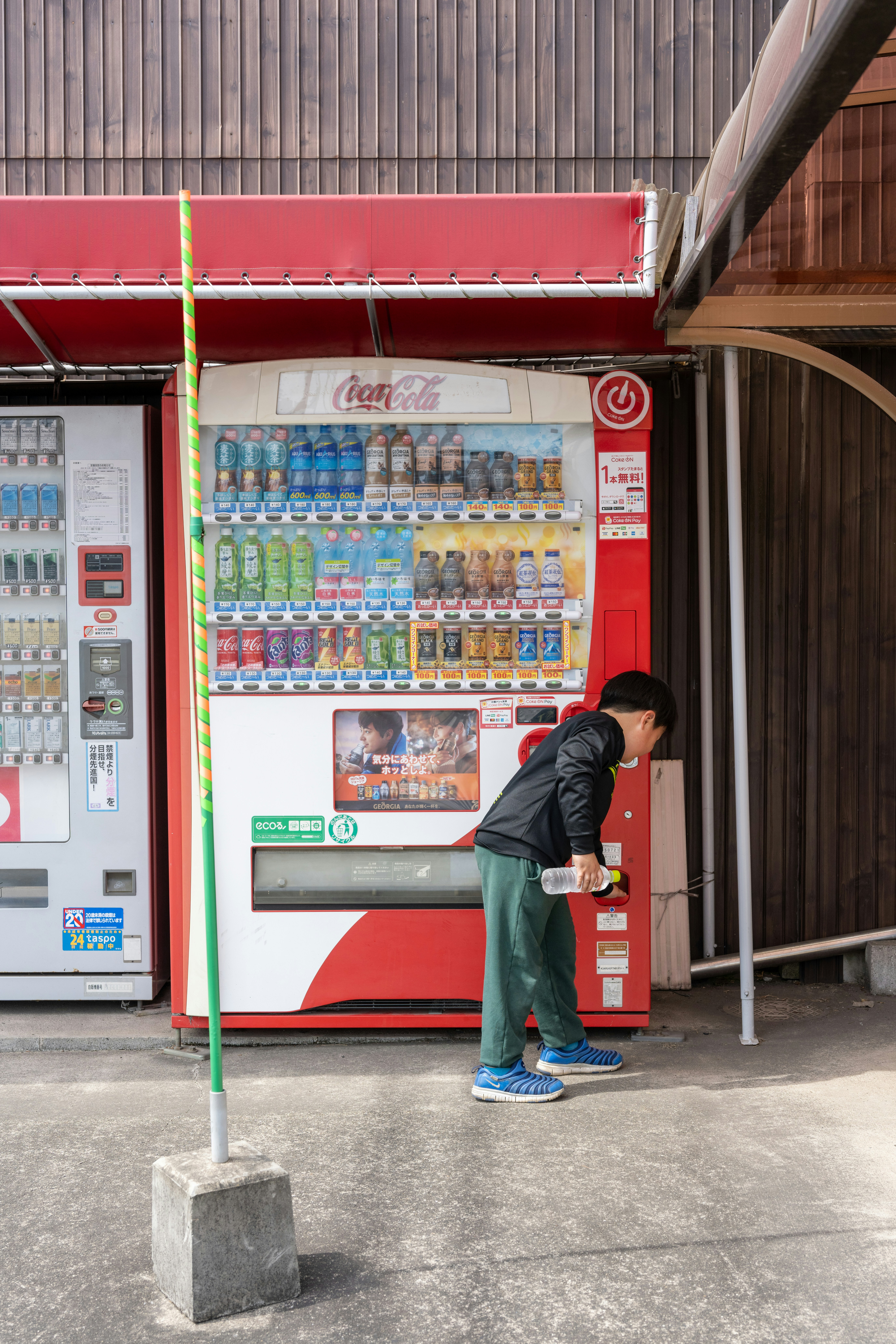 A man standing in front of a vending machine photo – Free Boy Image on ...