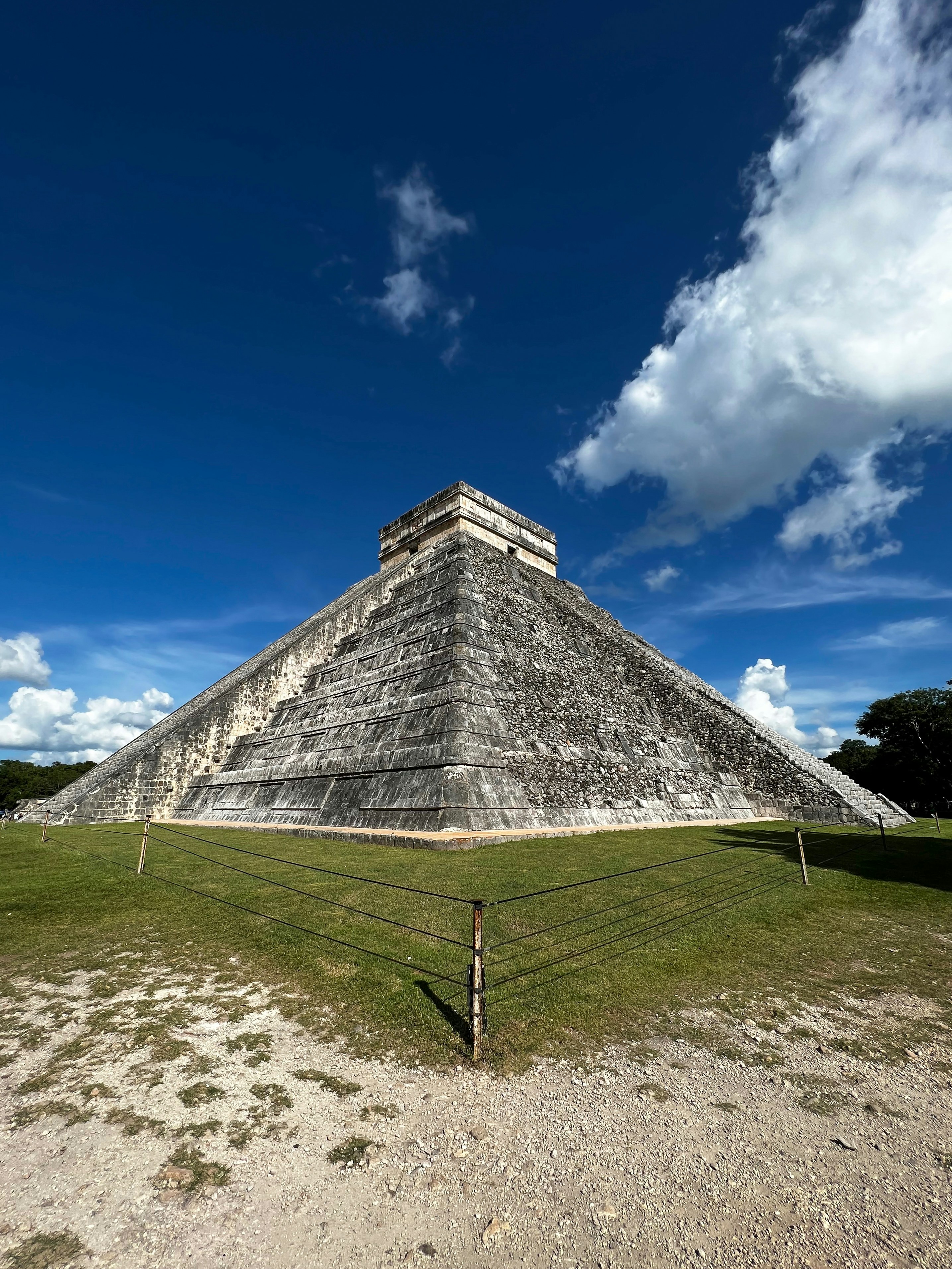 A large pyramid sitting on top of a lush green field photo – Free ...