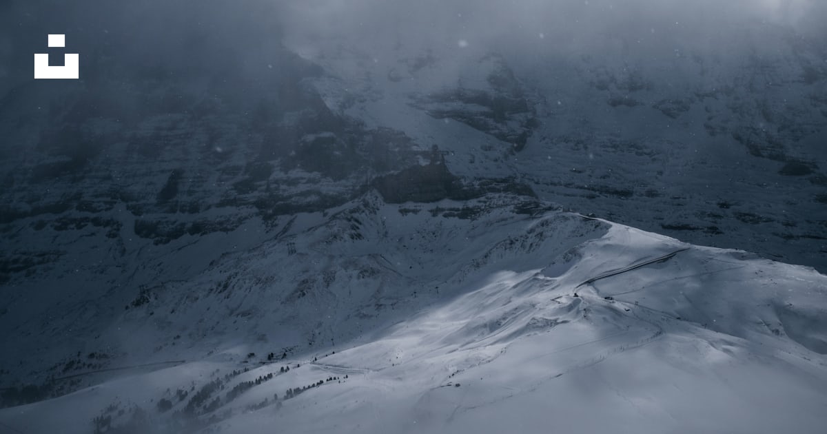 Une Montagne Couverte De Neige Sous Un Ciel Nuageux Photo Image
