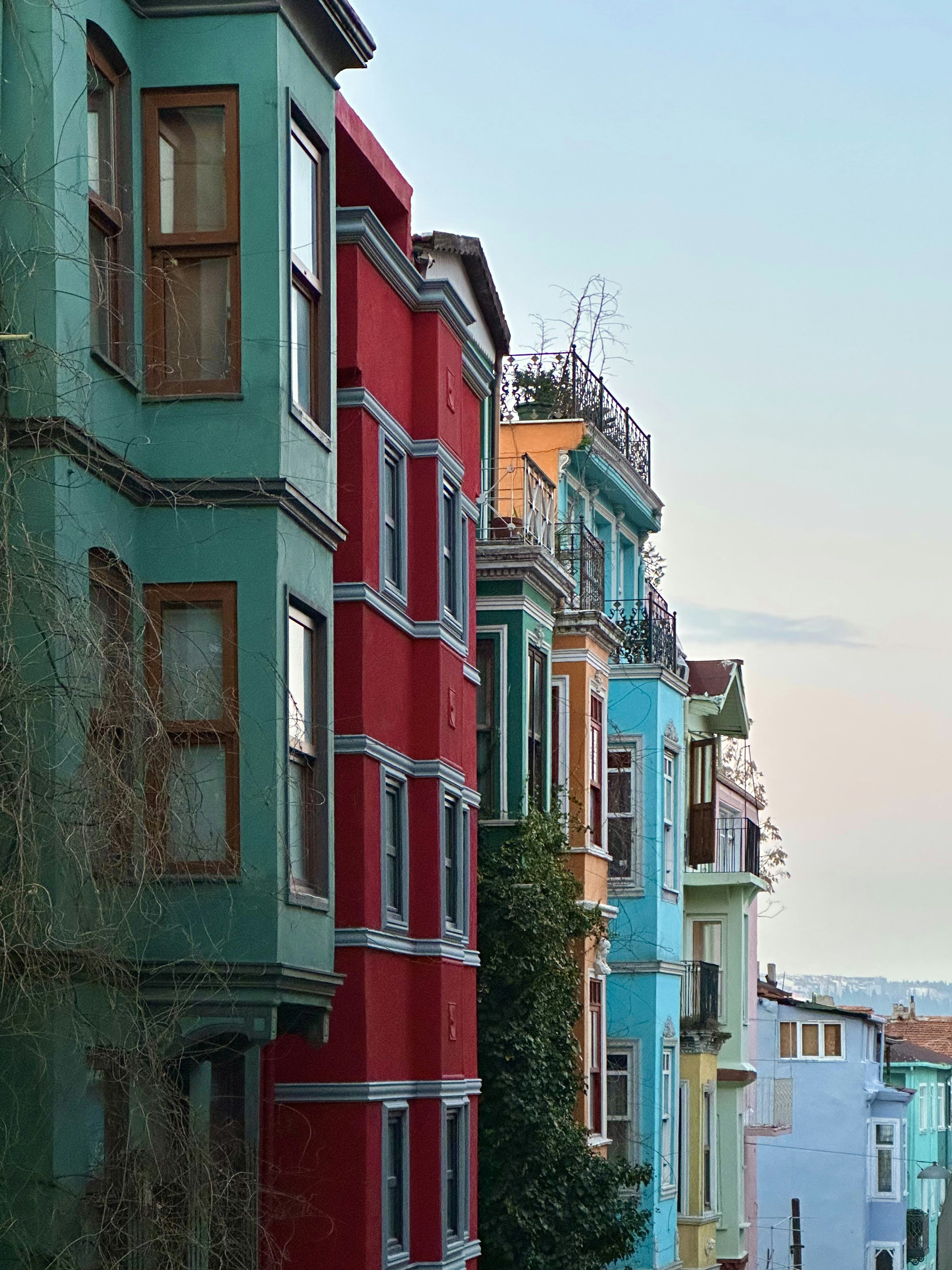 A row of multicolored buildings along a street photo – Free Balat ...