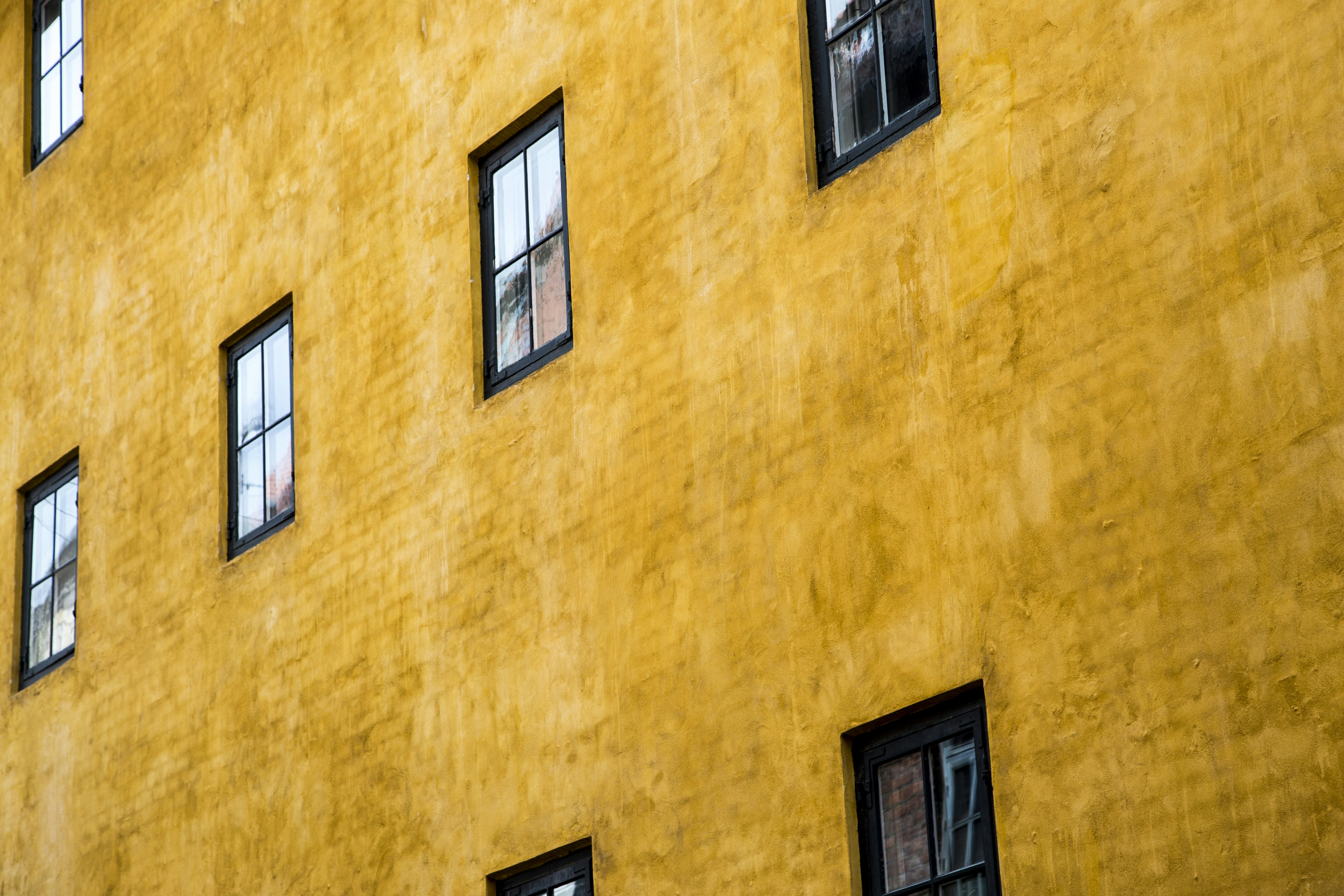 Un bâtiment jaune avec plusieurs fenêtres et une horloge photo – Photo ...