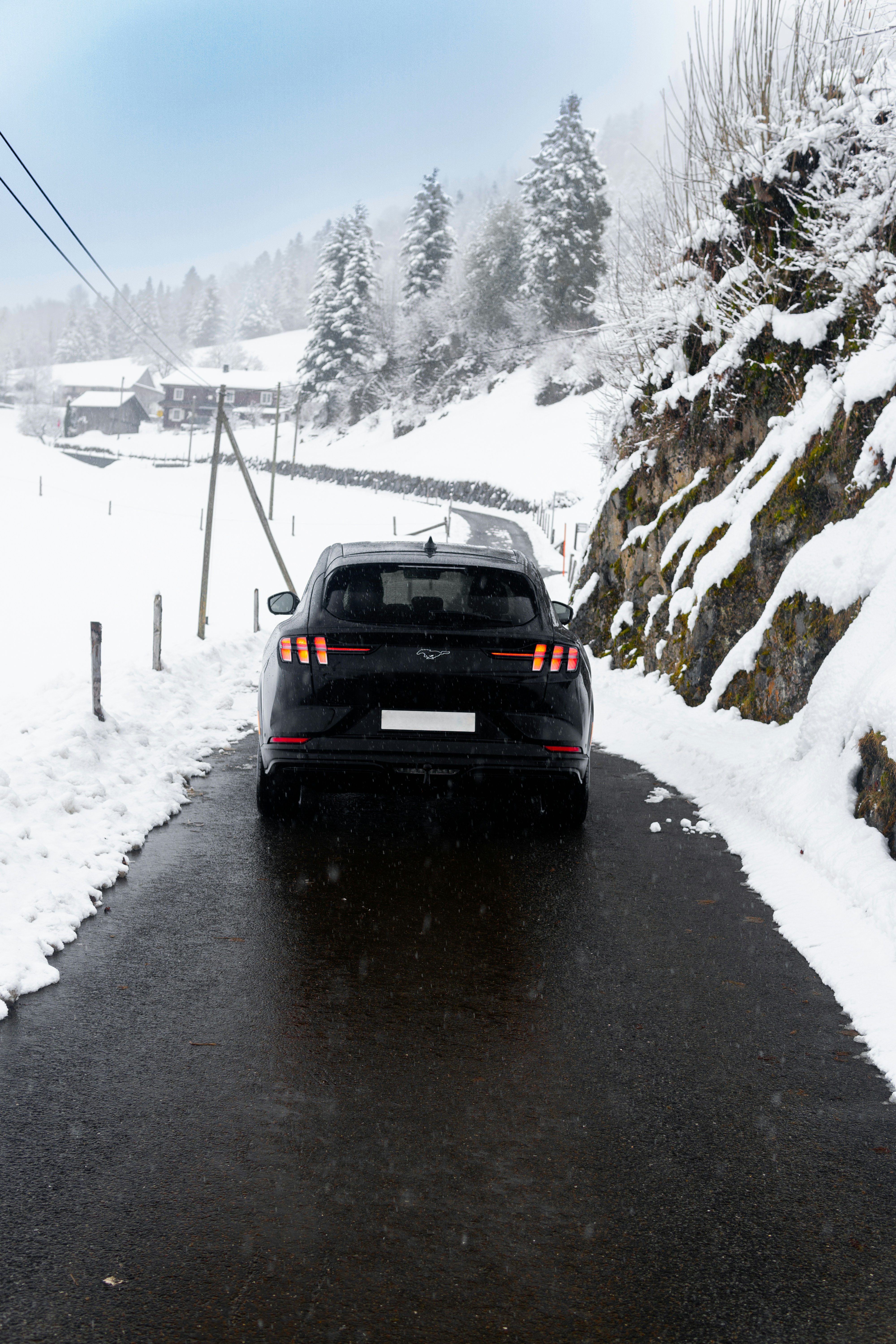 Vanishing Village in Snow: A Black SUV Traverses a Quiet Mountain Road